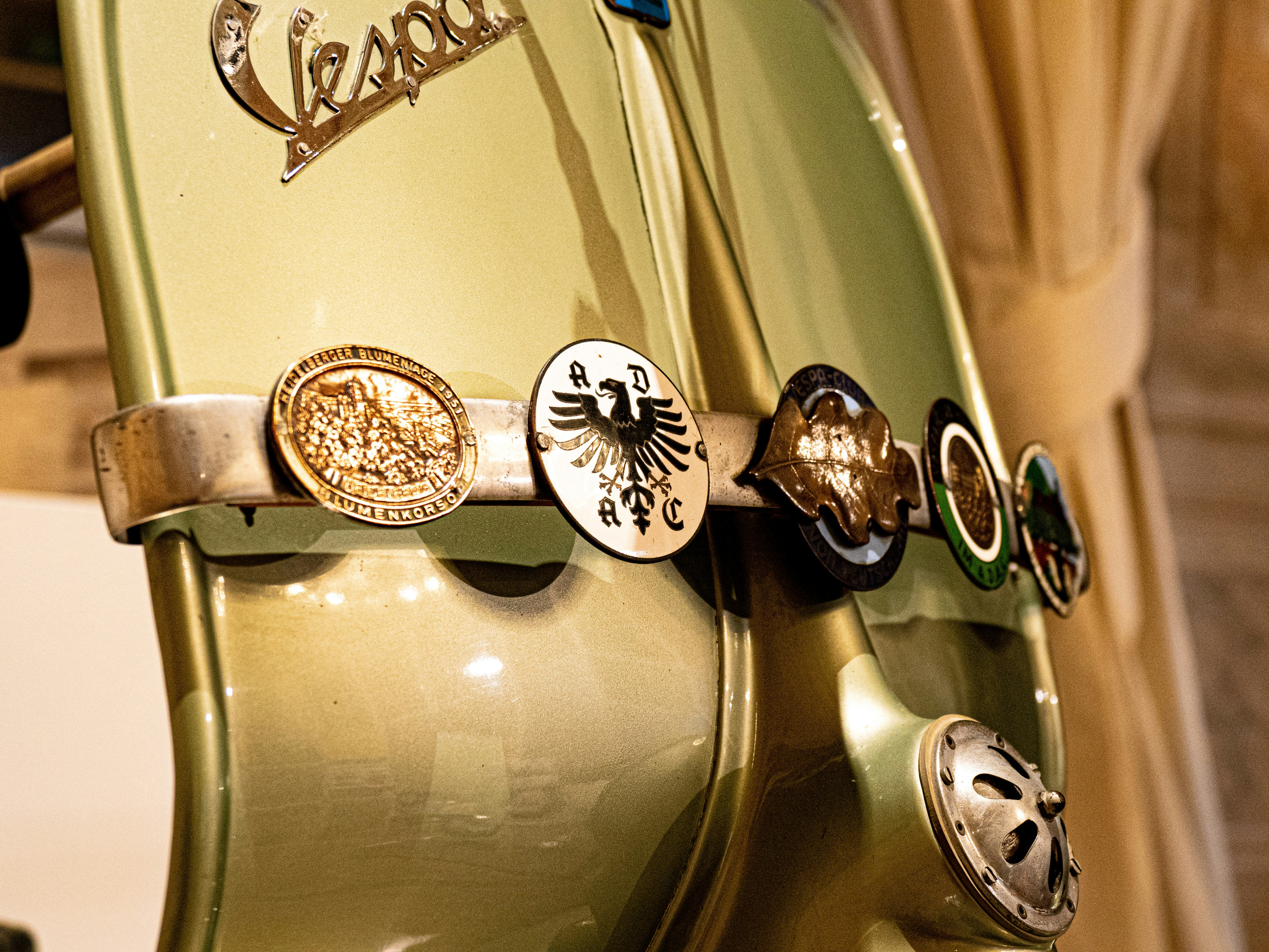 Badge Parade on a Vintage Green Vespa