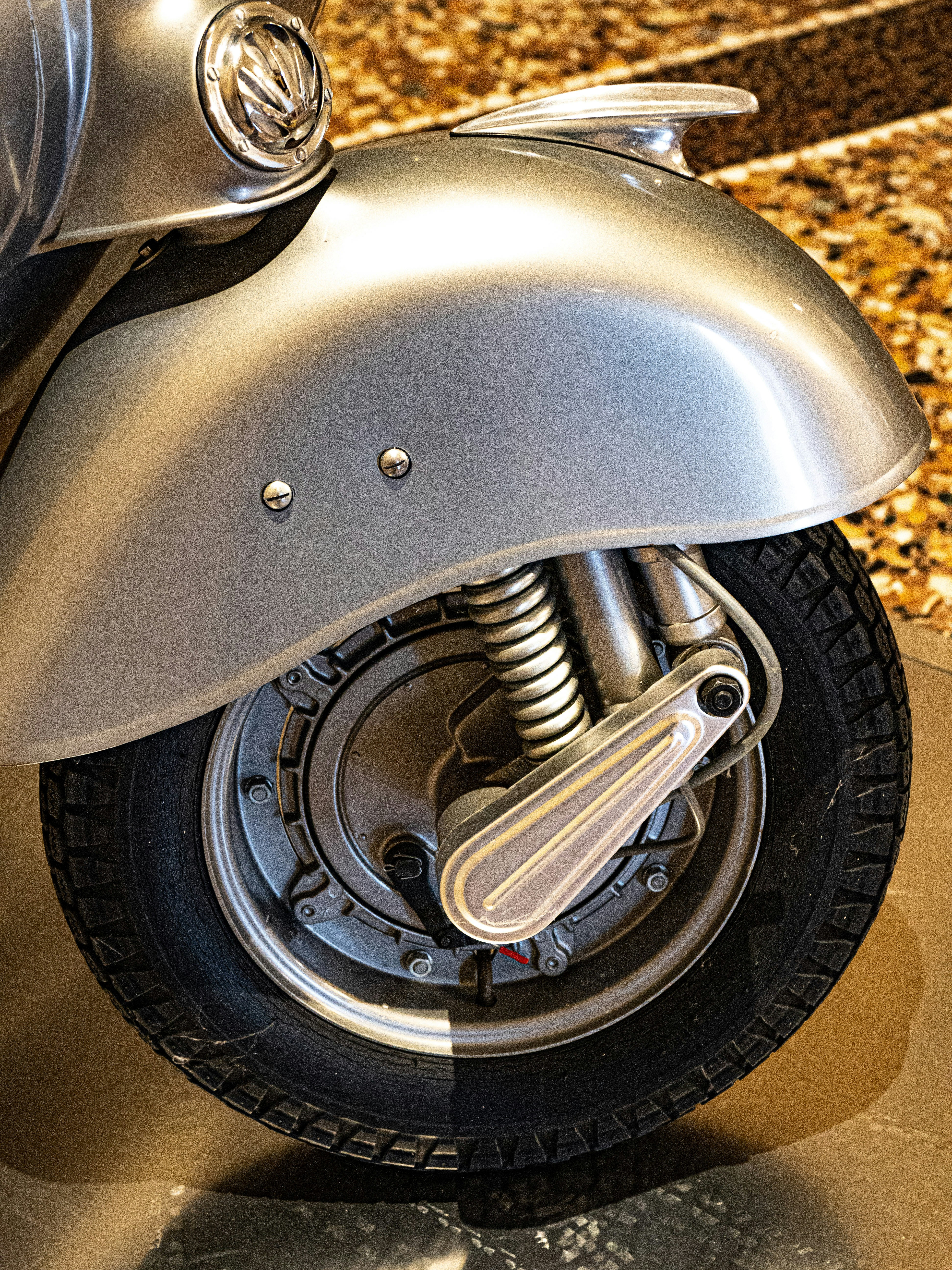 Chrome and Steel: Close-Up of a Silver Scooter Front Wheel