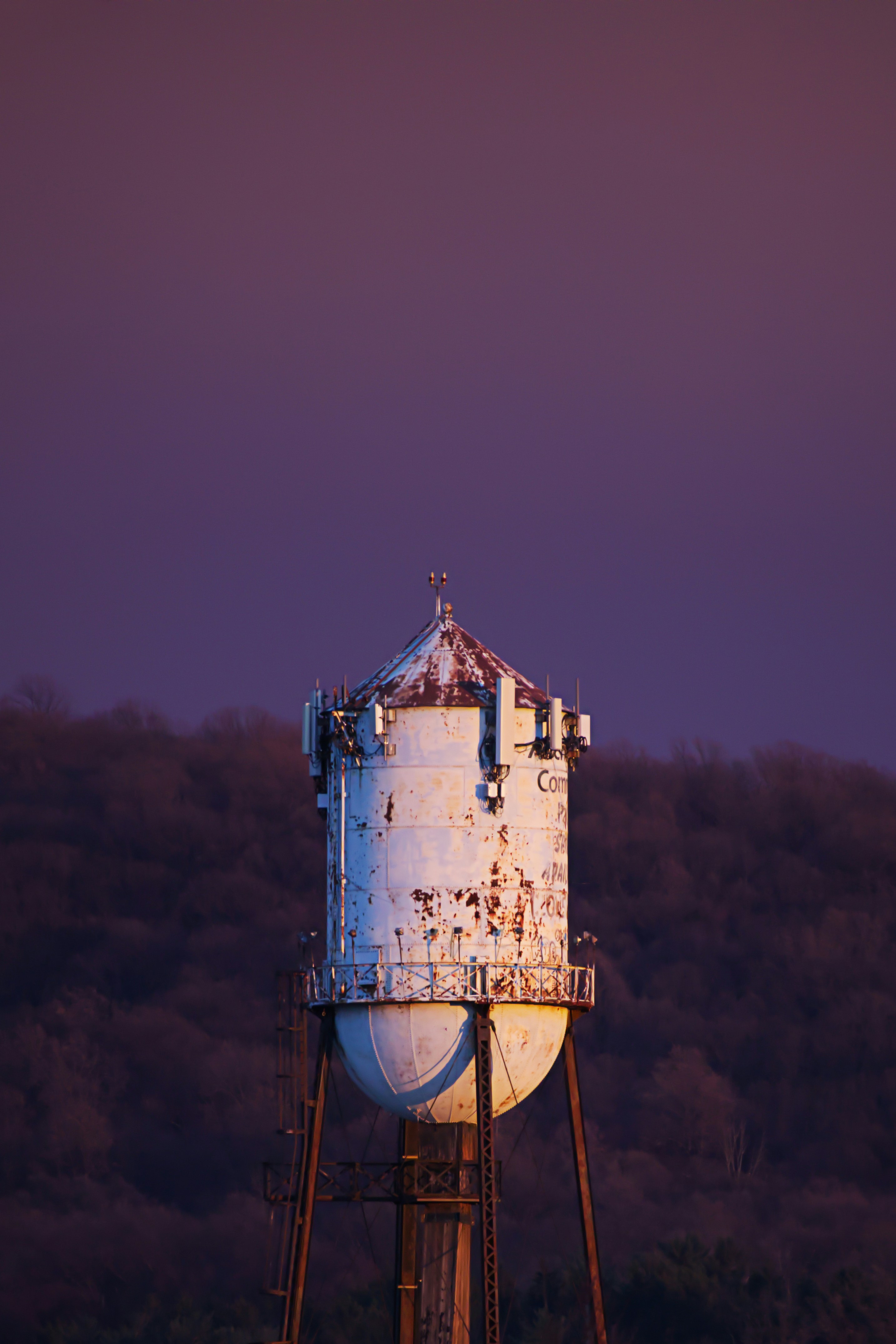 Twilight Sentinel: A Rusted Water Tower Under Violet Dusk