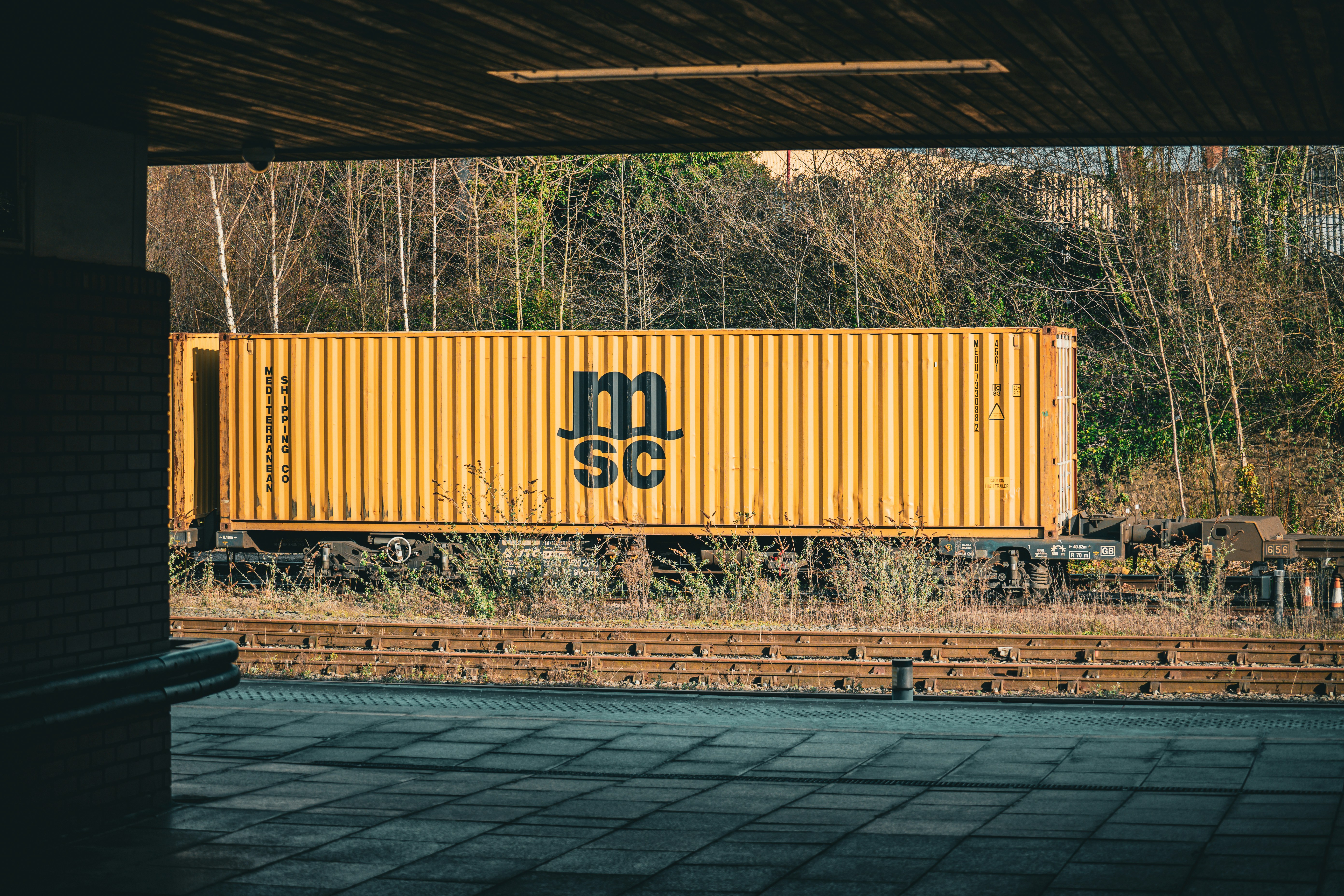 Yellow shipping container on train tracks. photo – Free Train Image on ...