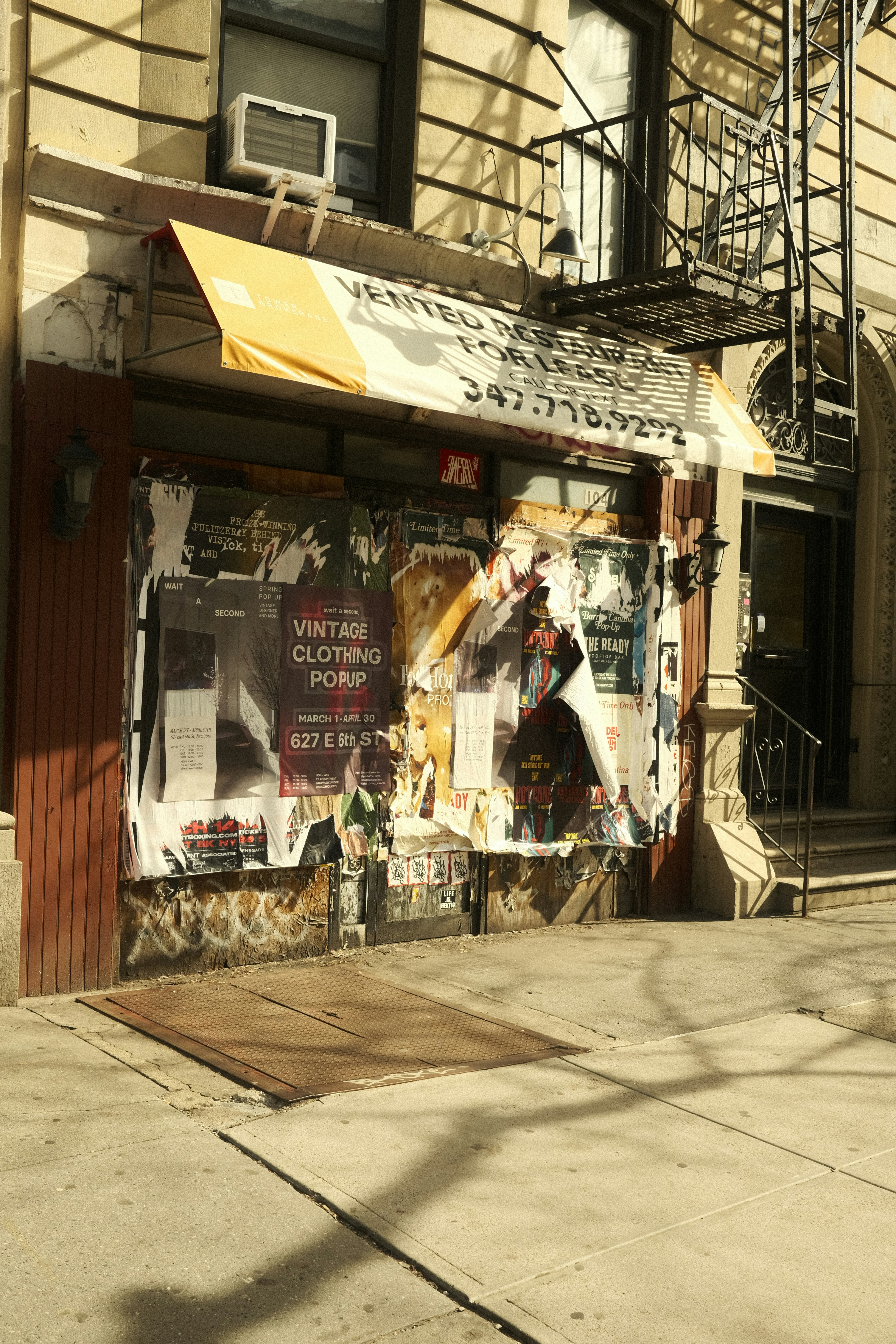 A closed storefront covered in posters and a canopy. photo – Free ...