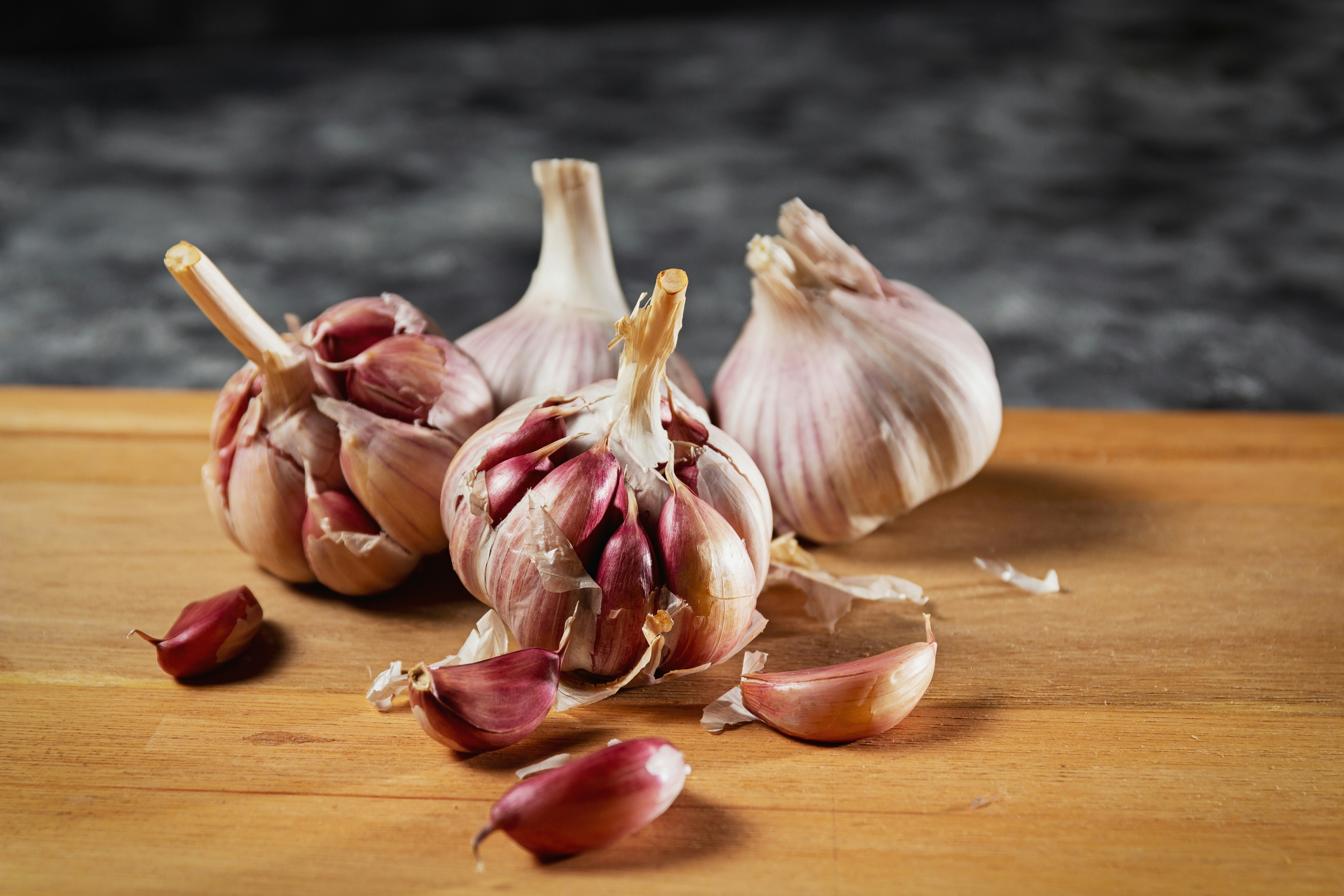 Garlic Trio on a Sunlit Cutting Board: A Quiet, Textured Still Life