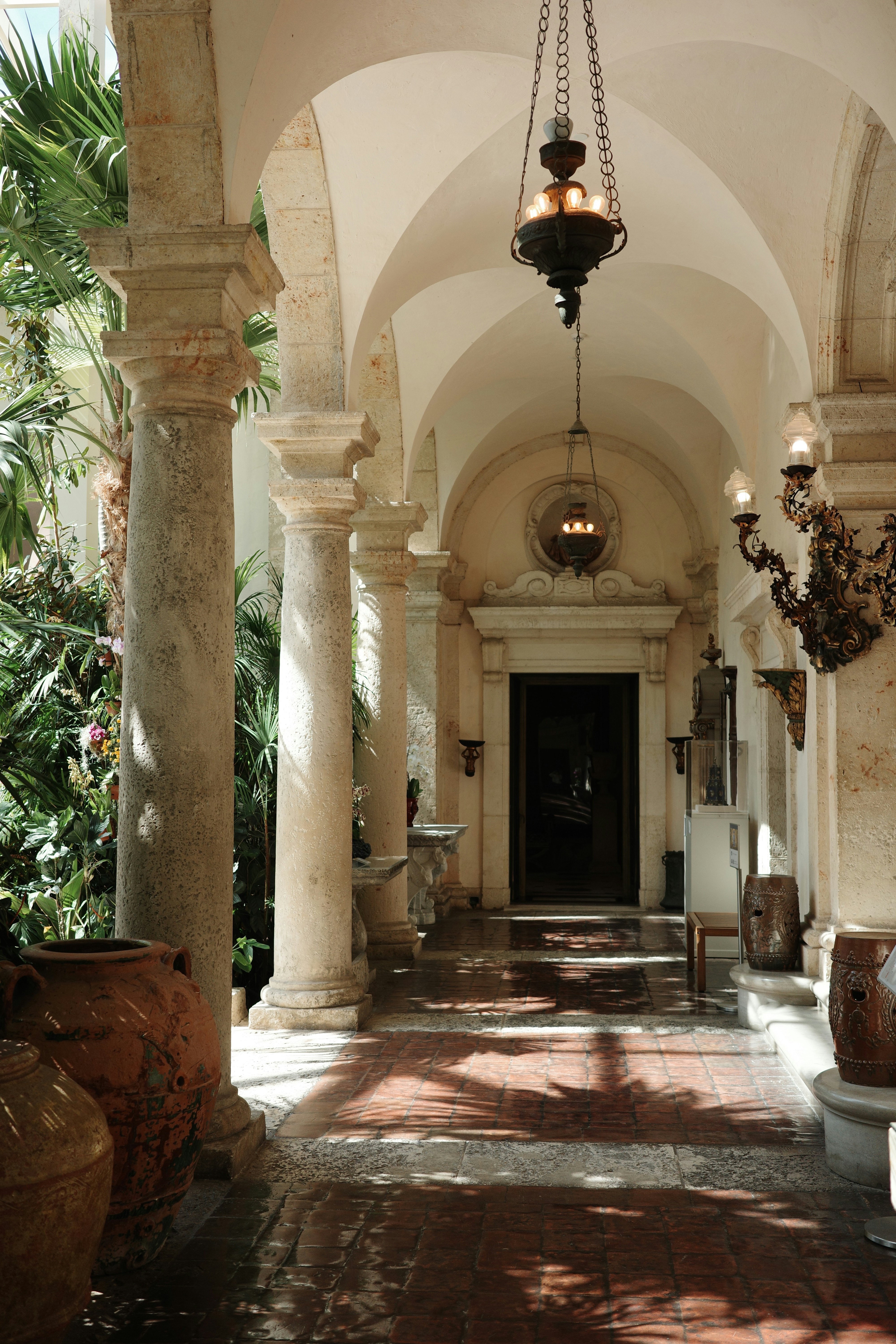 Elegant arched corridor with hanging lanterns and soft sunlight casting intricate shadows.