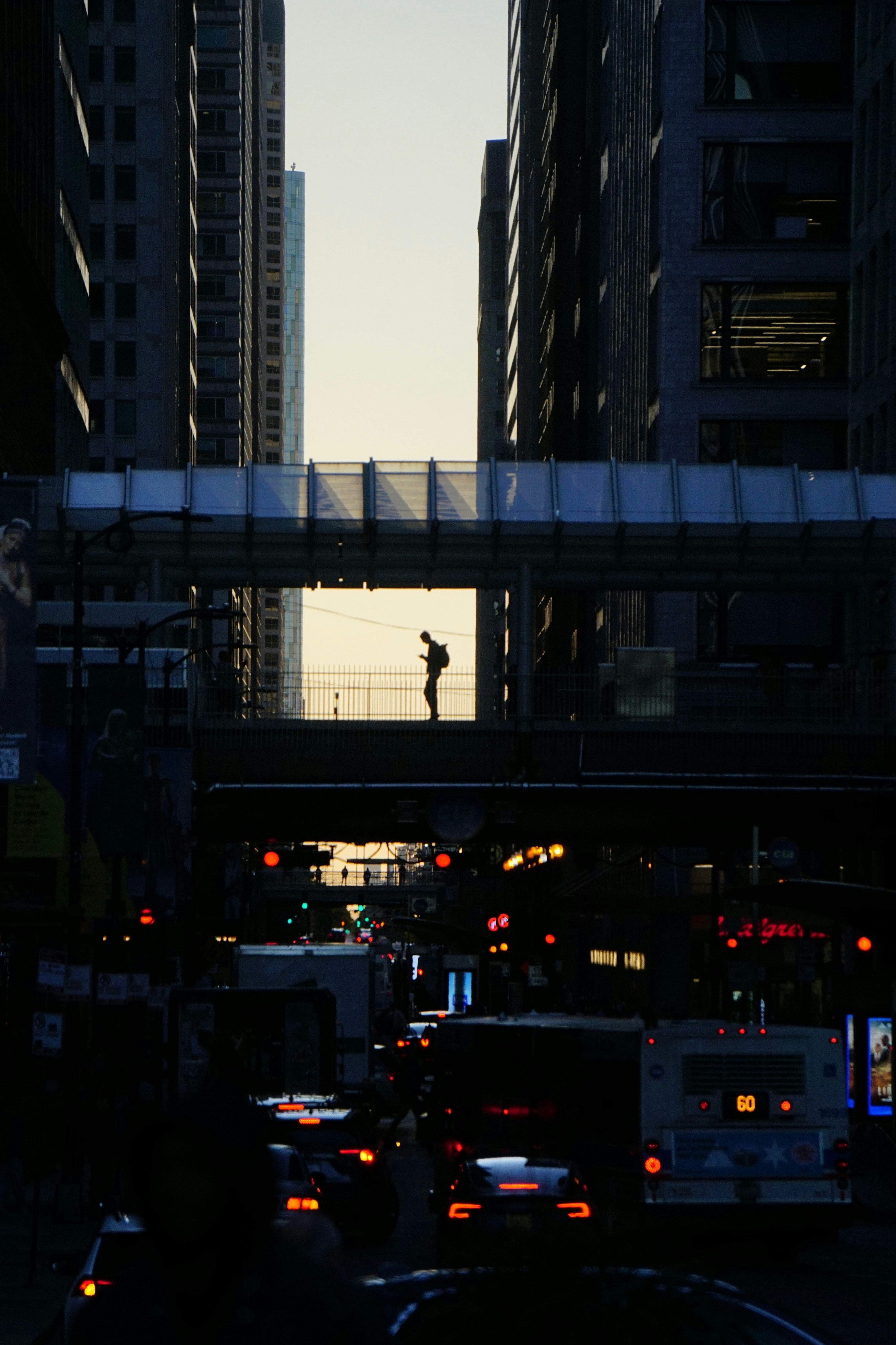 A person stands on a skybridge amidst city buildings. photo – Free Car ...