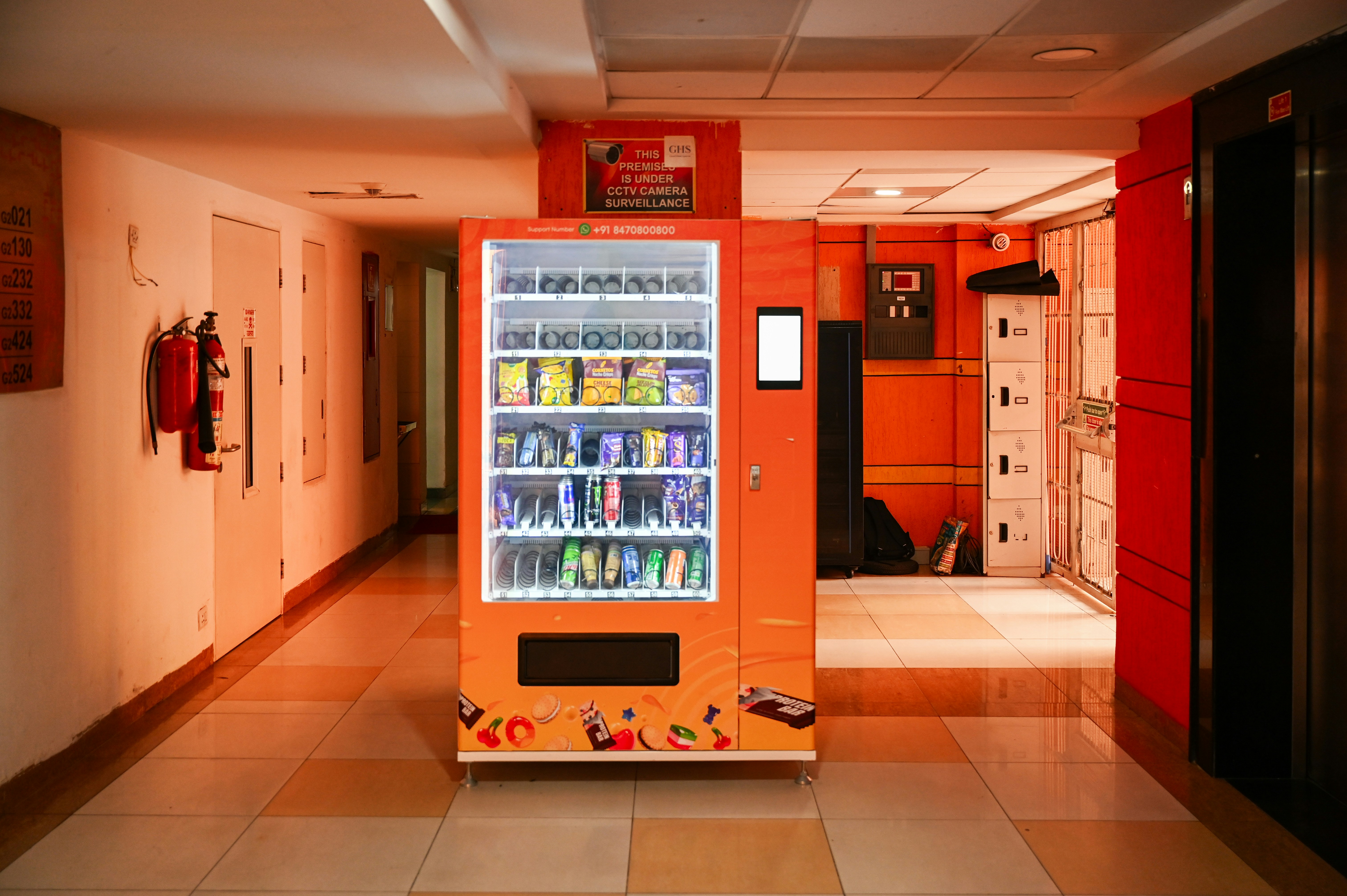 A vending machine stands in an office hallway. photo – Free India Image ...