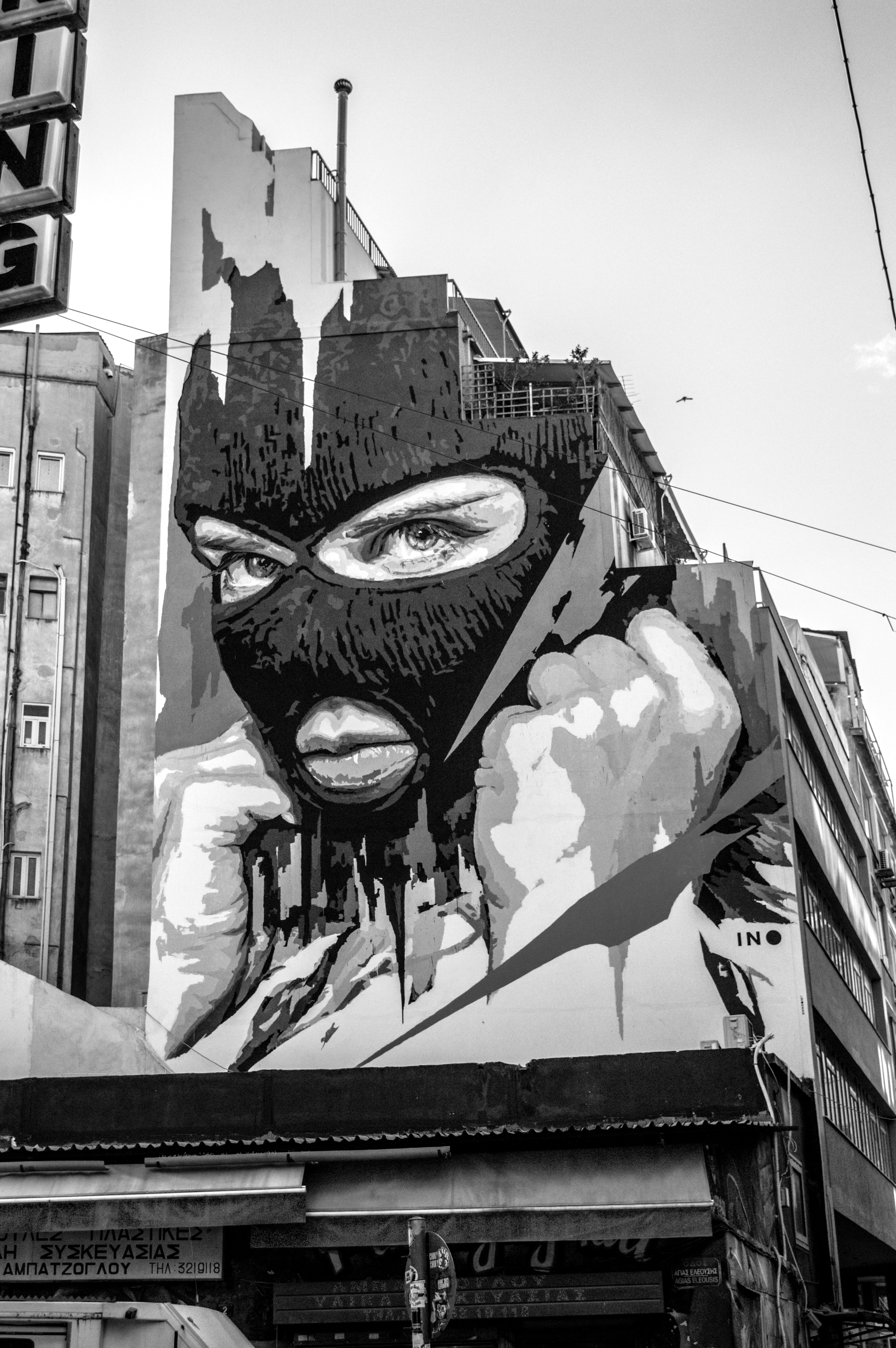A black and white mural depicts a person in a balaclava. photo – Free ...