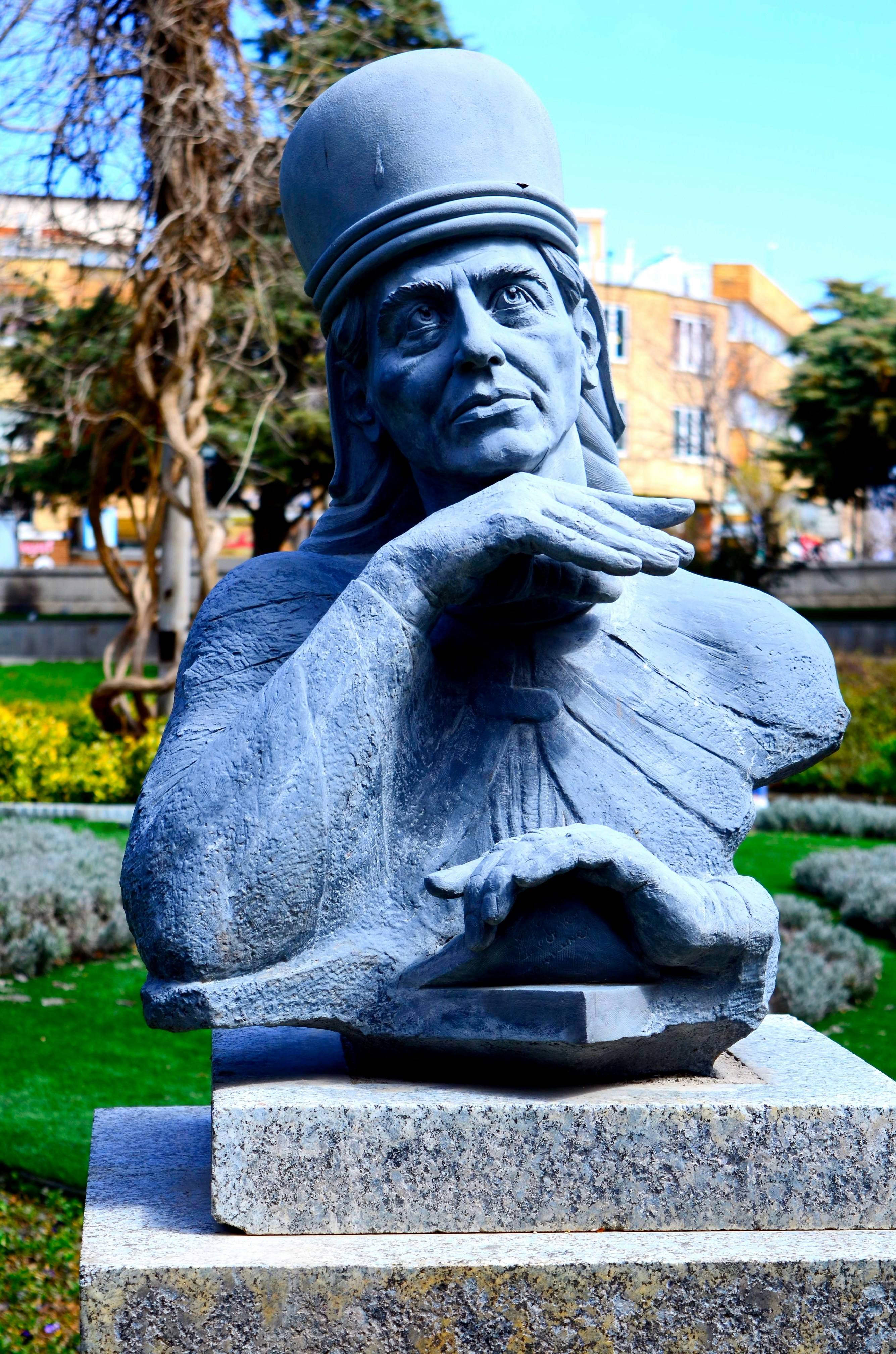 Azure Vigil in the Park: A blue-toned bust beneath urban light
