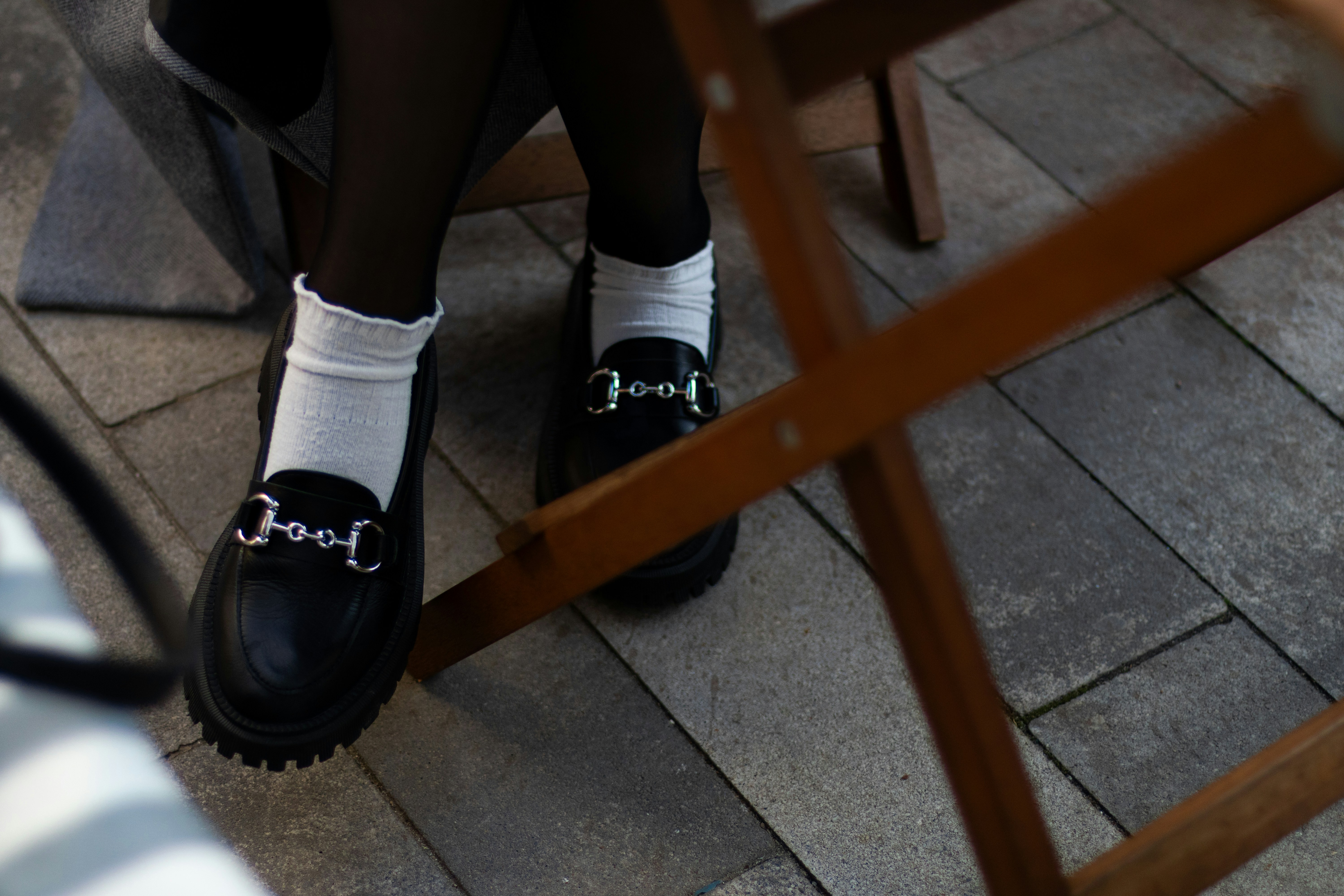 Feet wearing stylish shoes are seen beneath a table. photo – Free Girl ...