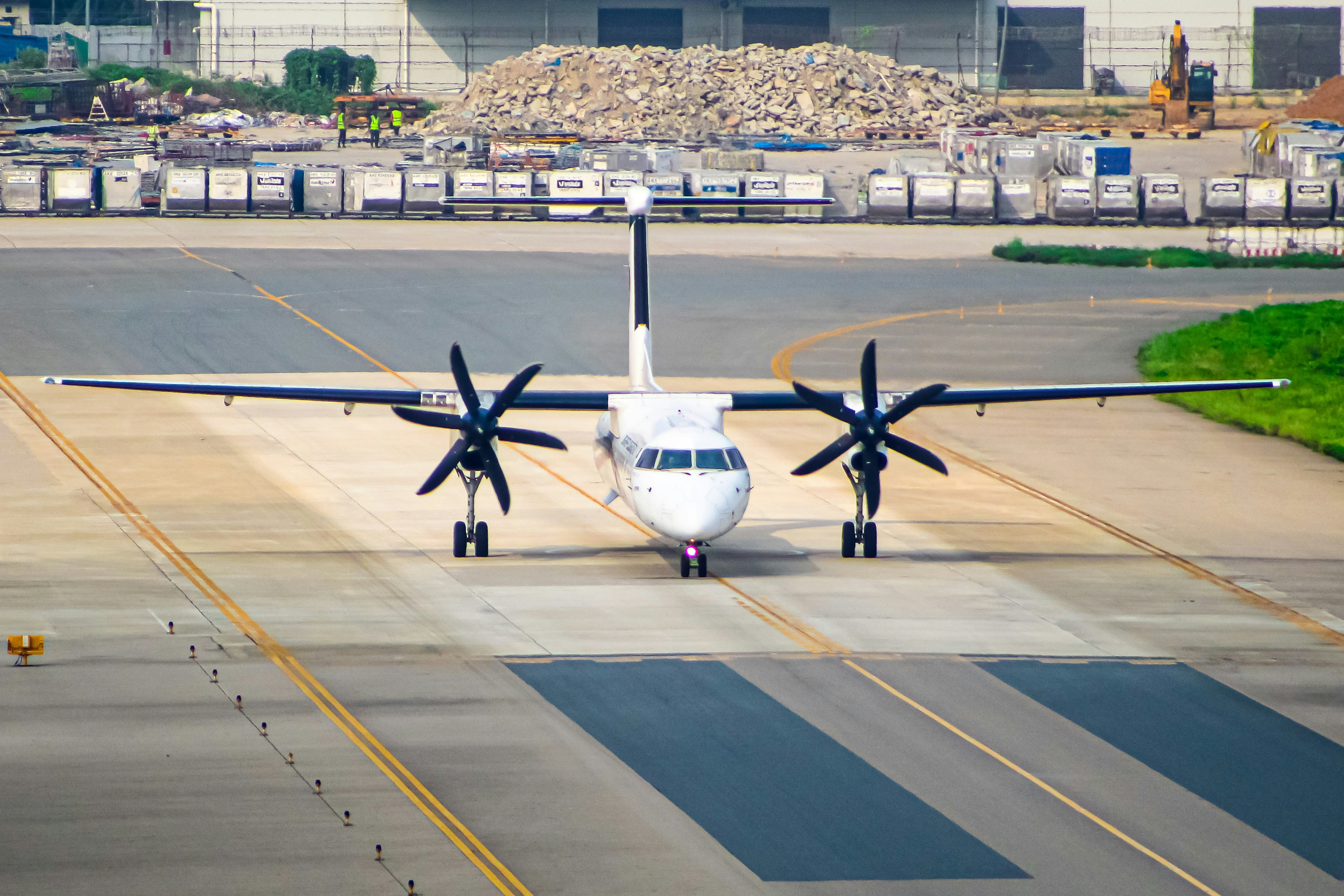 Twin-propeller aircraft on an airport runway ready for departure.