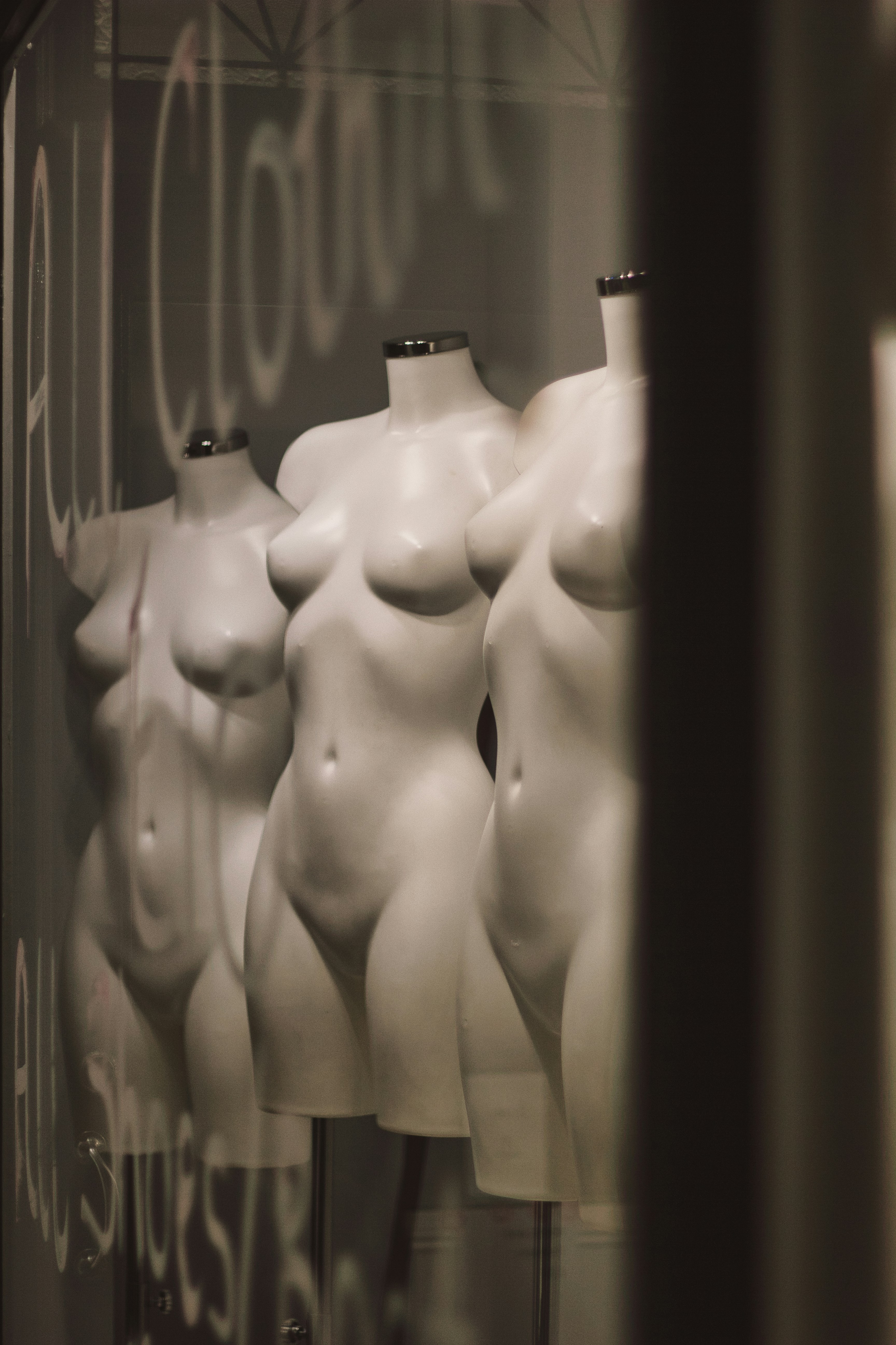 Muted Spotlight: A Trio of Mannequins in a Sepia Storefront Window