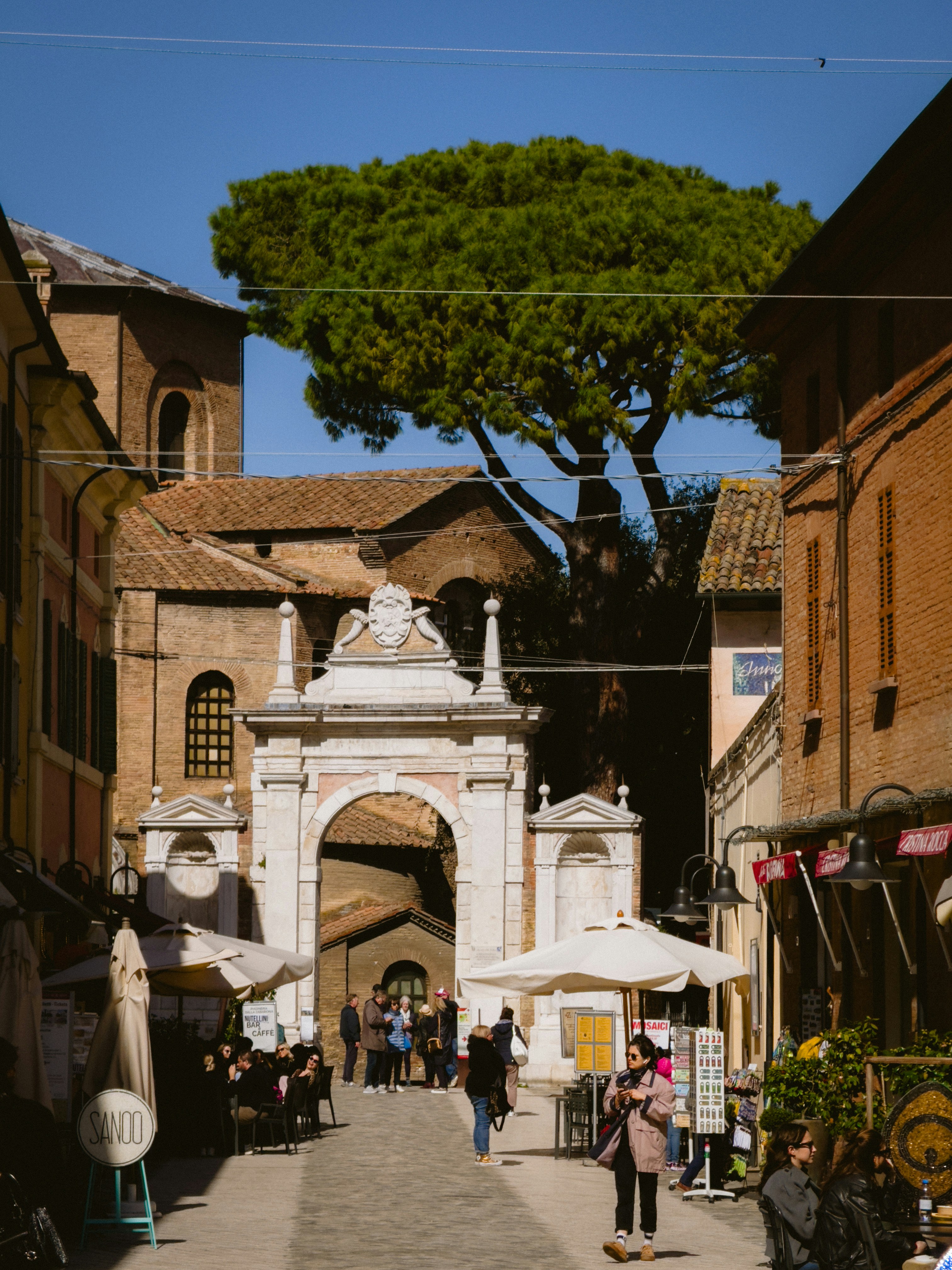 Stone Archway in a Quiet Piazza Framed by a Central Tree