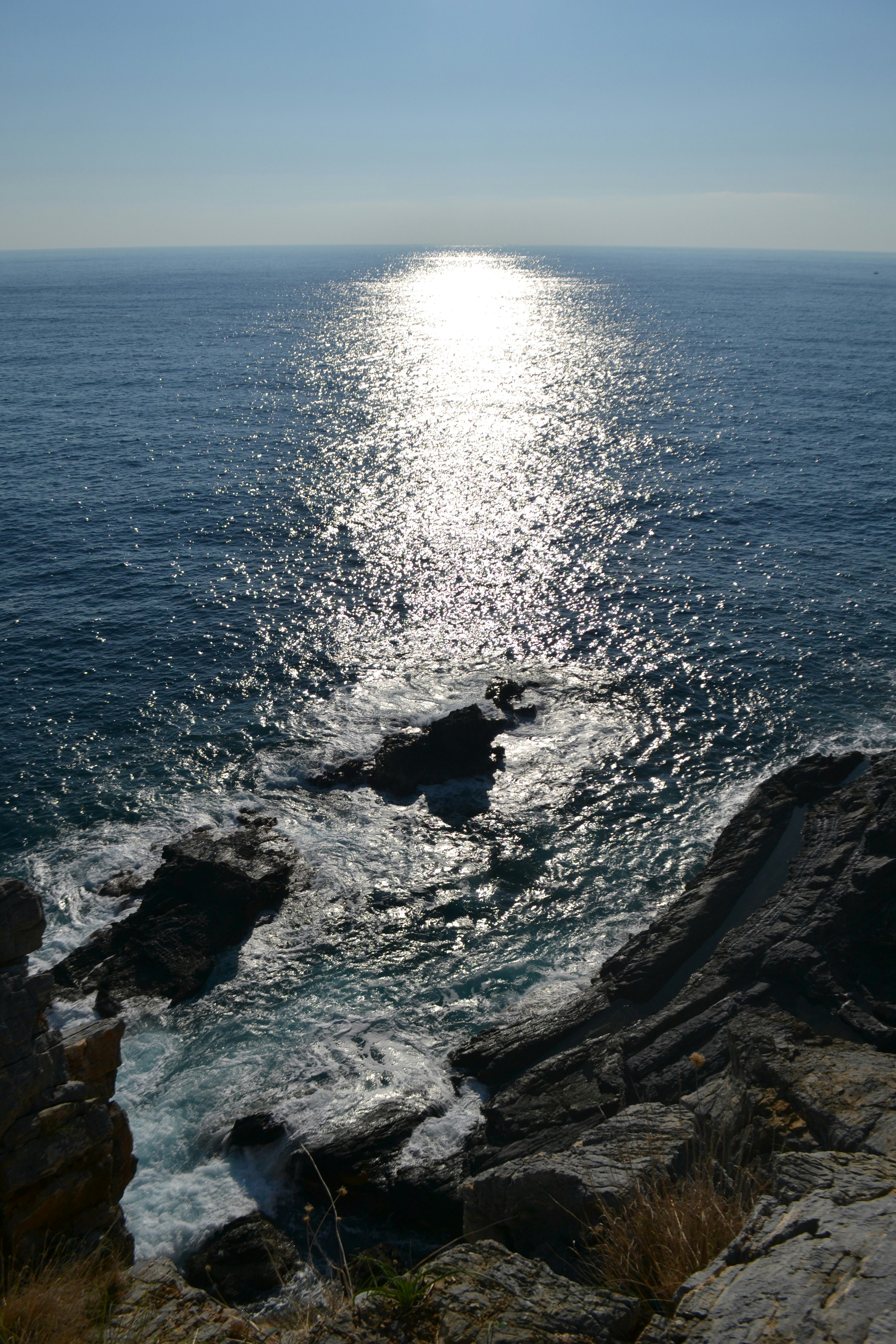 Sunlit Path Across the Ocean: A Cliffside Moment