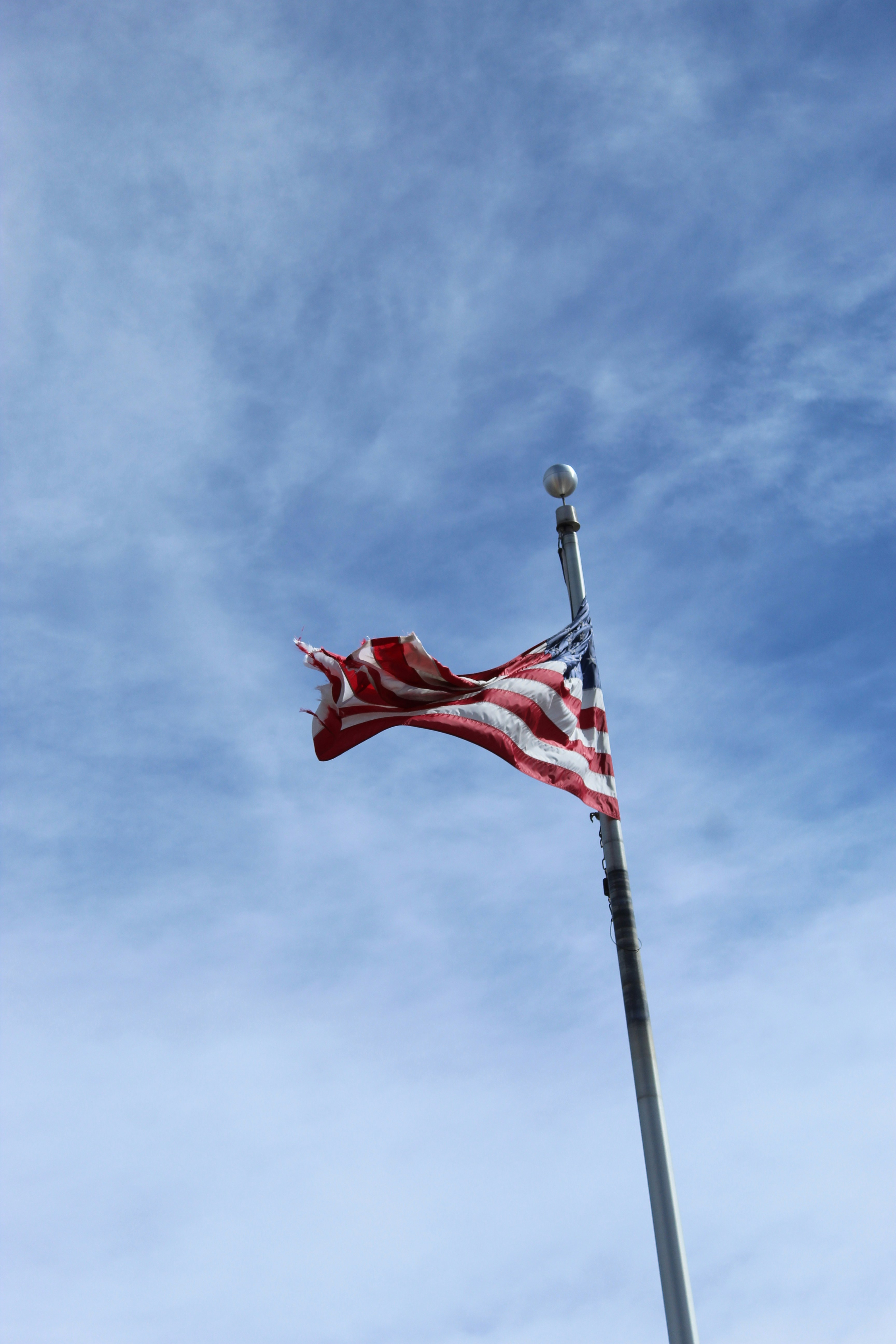 The american flag flies in a blue sky. photo – Free American flag Image ...
