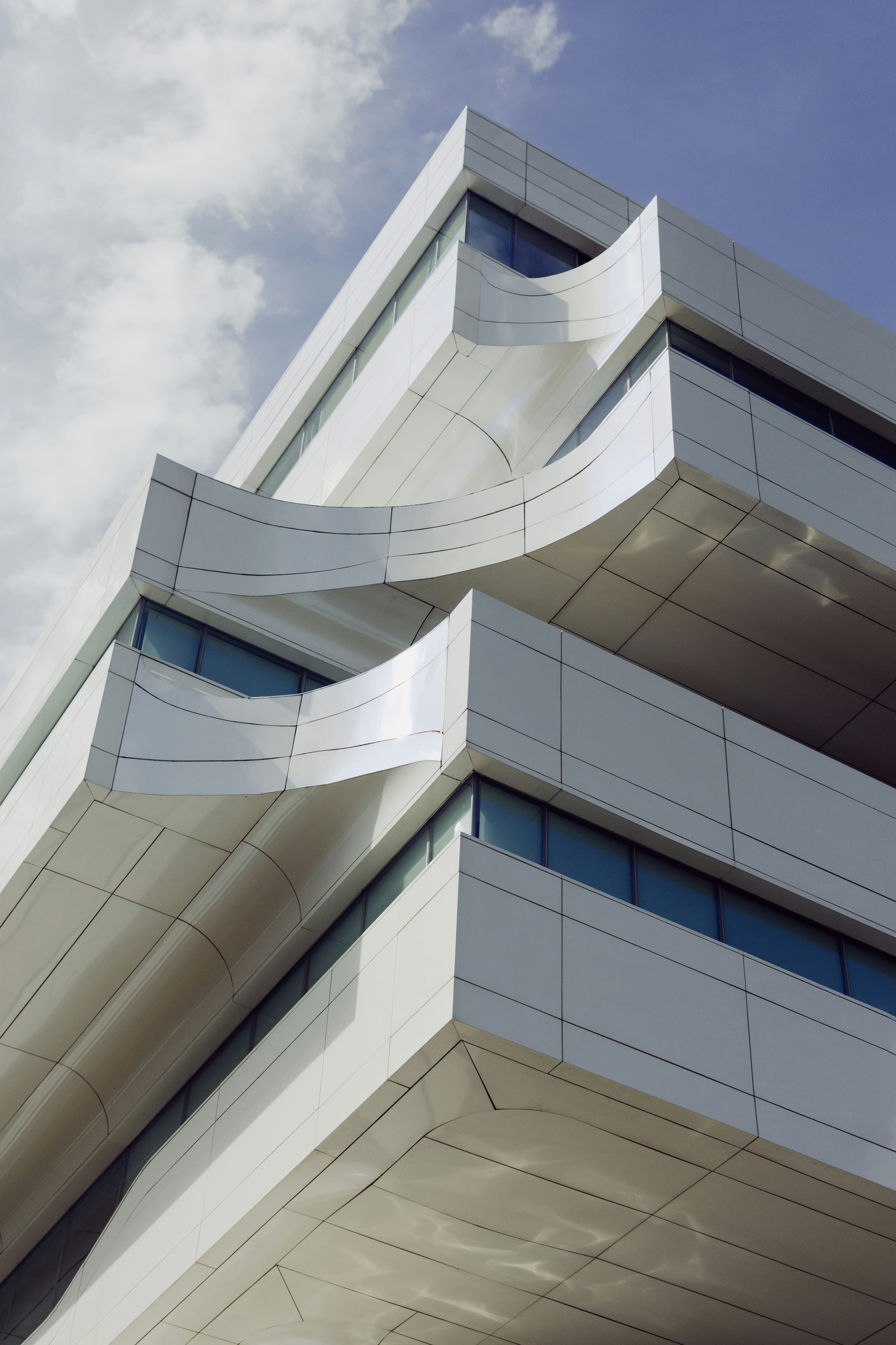 A modern white building against a cloudy sky. photo – Free Building ...