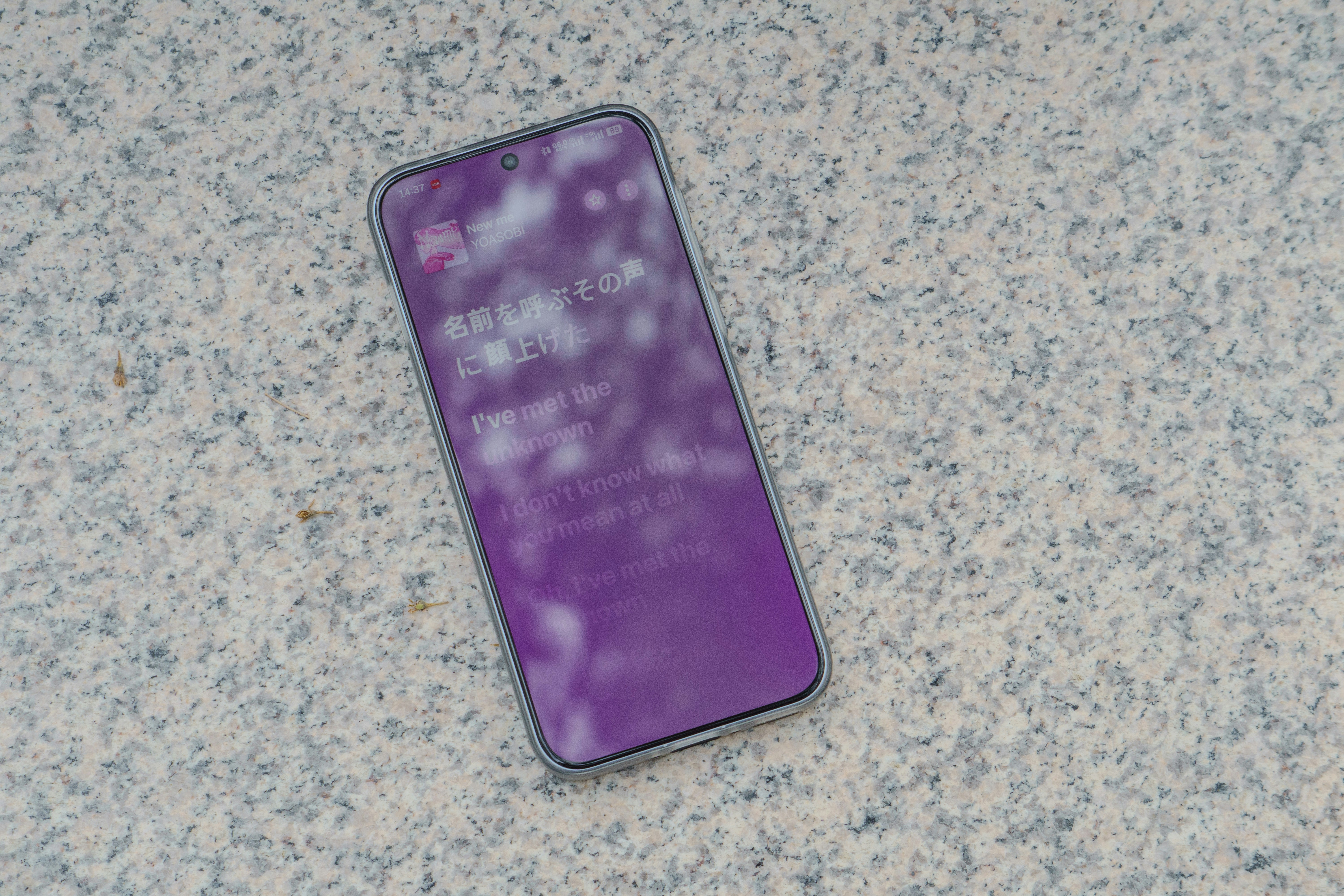 Diagonally Reclined Smartphone: Violet Screen on a Textured Granite Canvas