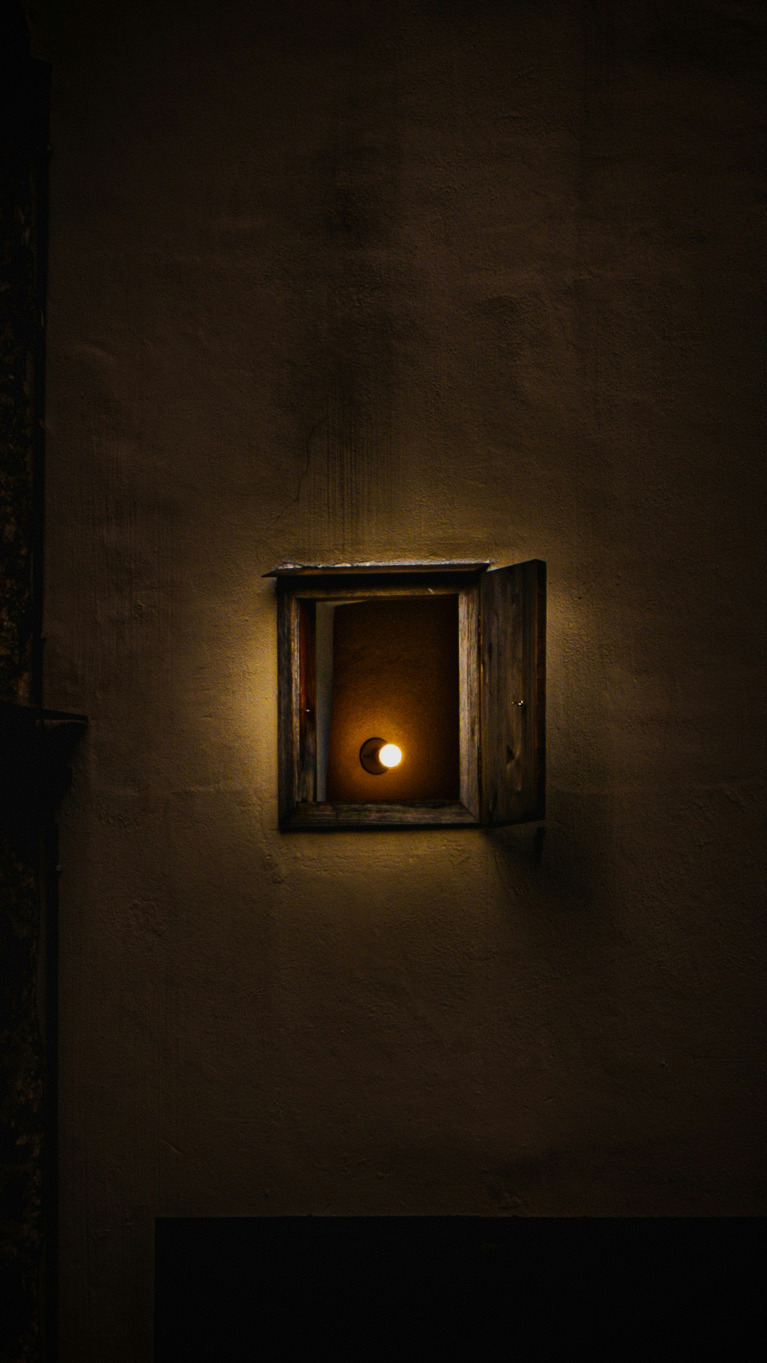 A lit window glows against a dark wall. photo – Free Moon Image on Unsplash