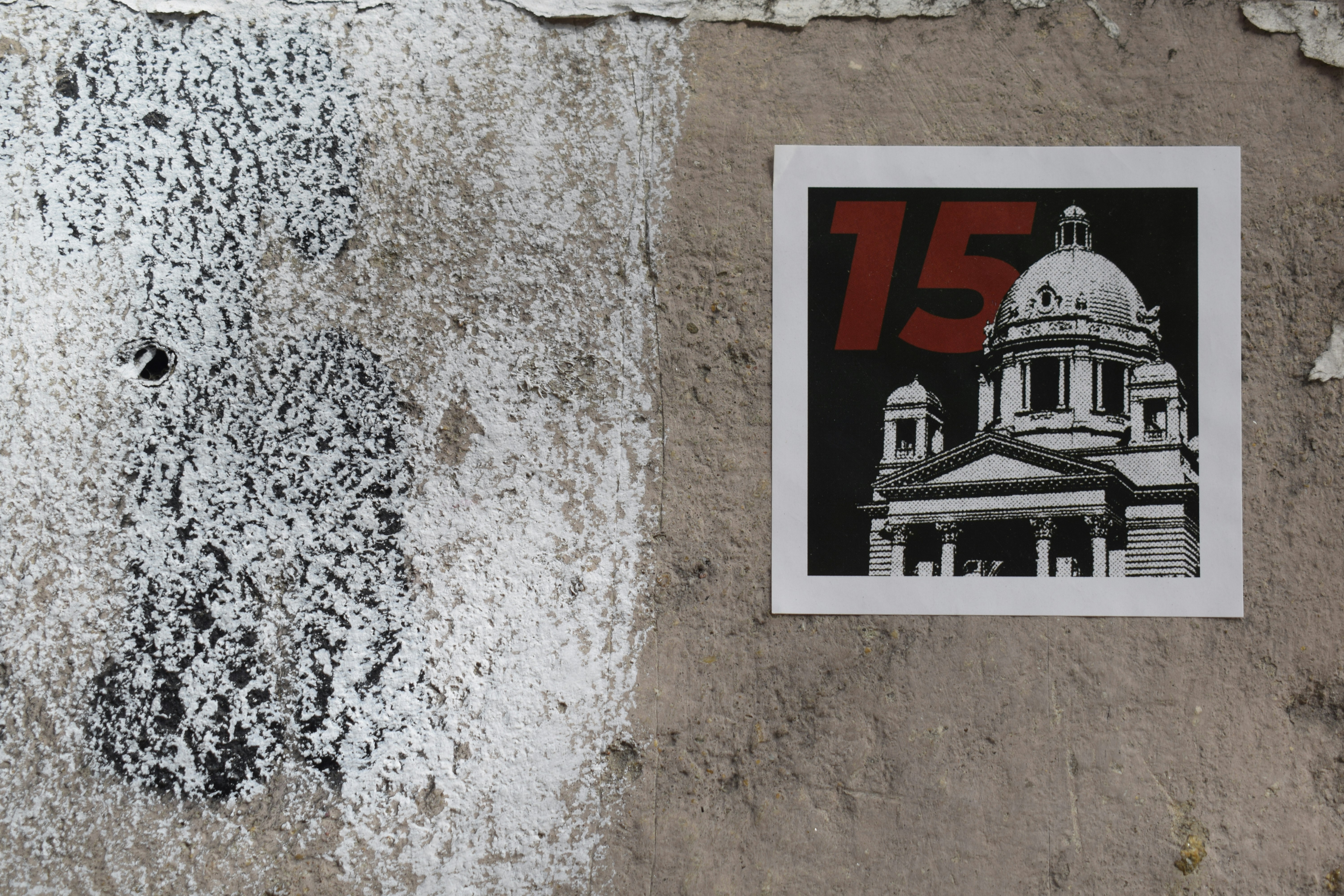 Red 15 Over a Weathered Dome: A Sticker of Time on a Cracked Wall