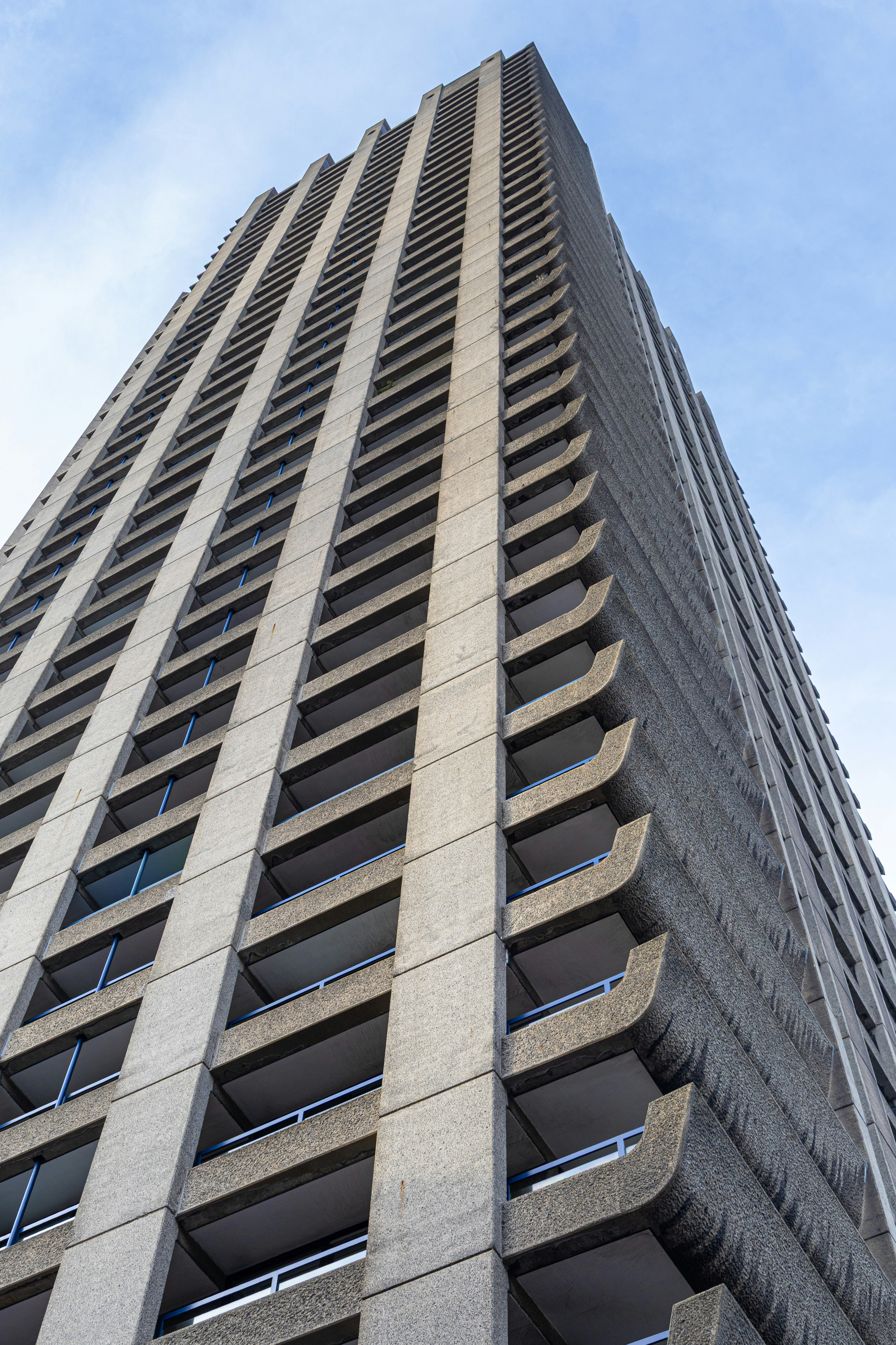 A tall concrete building reaches upward. photo – Free City Image on ...