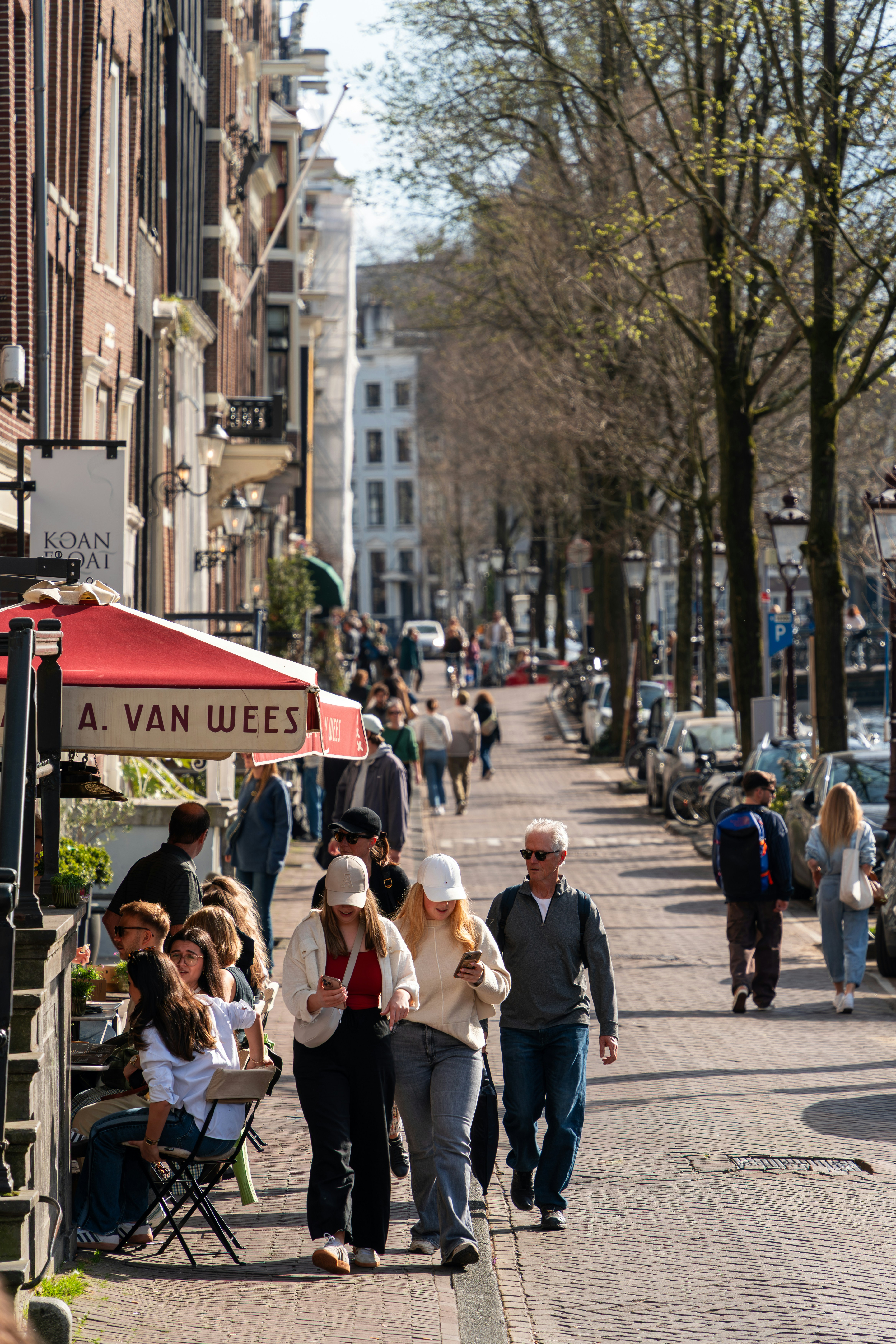 Morning Stroll Under a Café Umbrella on a Sunlit Dutch Street