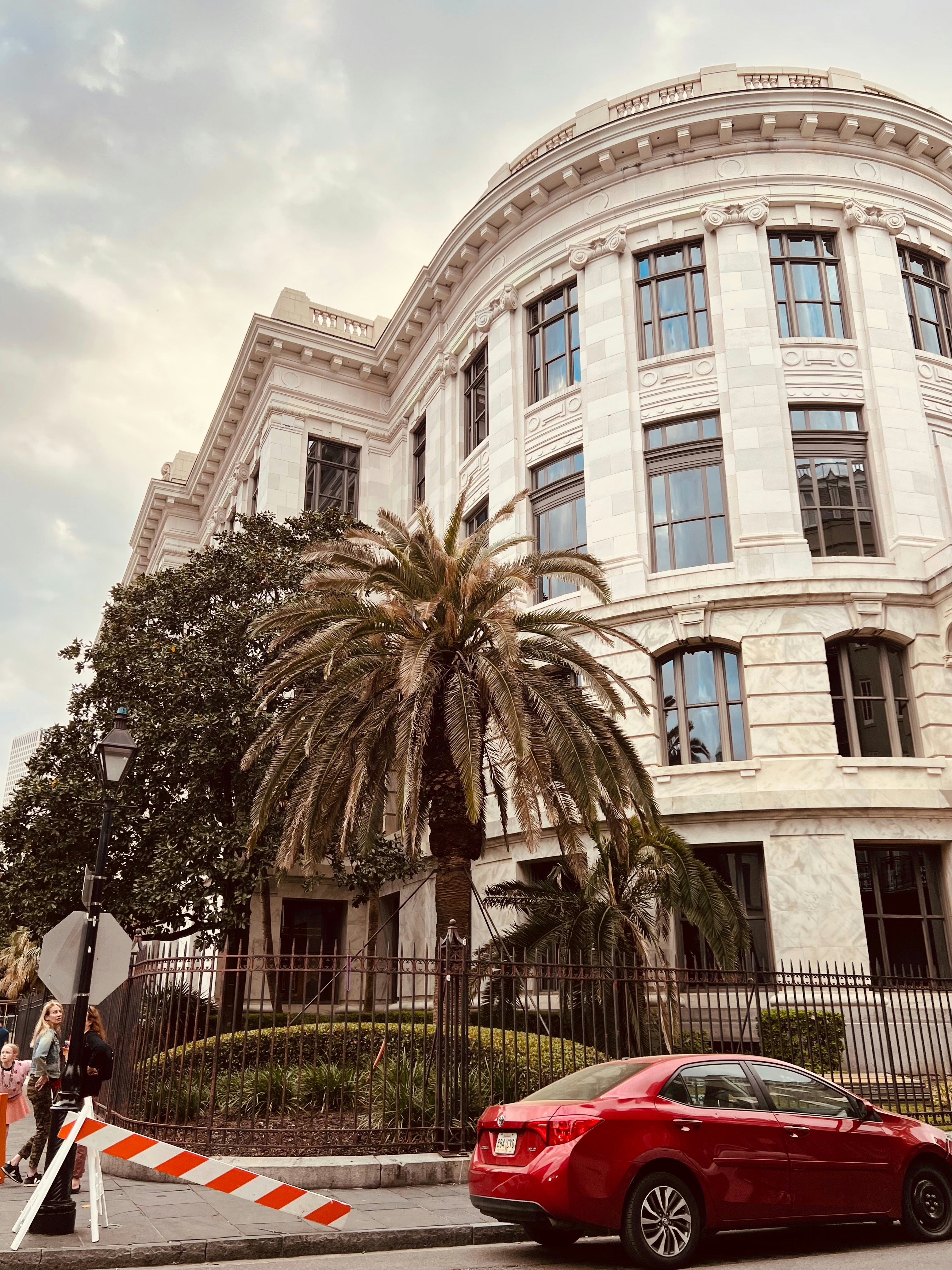 Urban Grand Facade with Palm and Red Car
