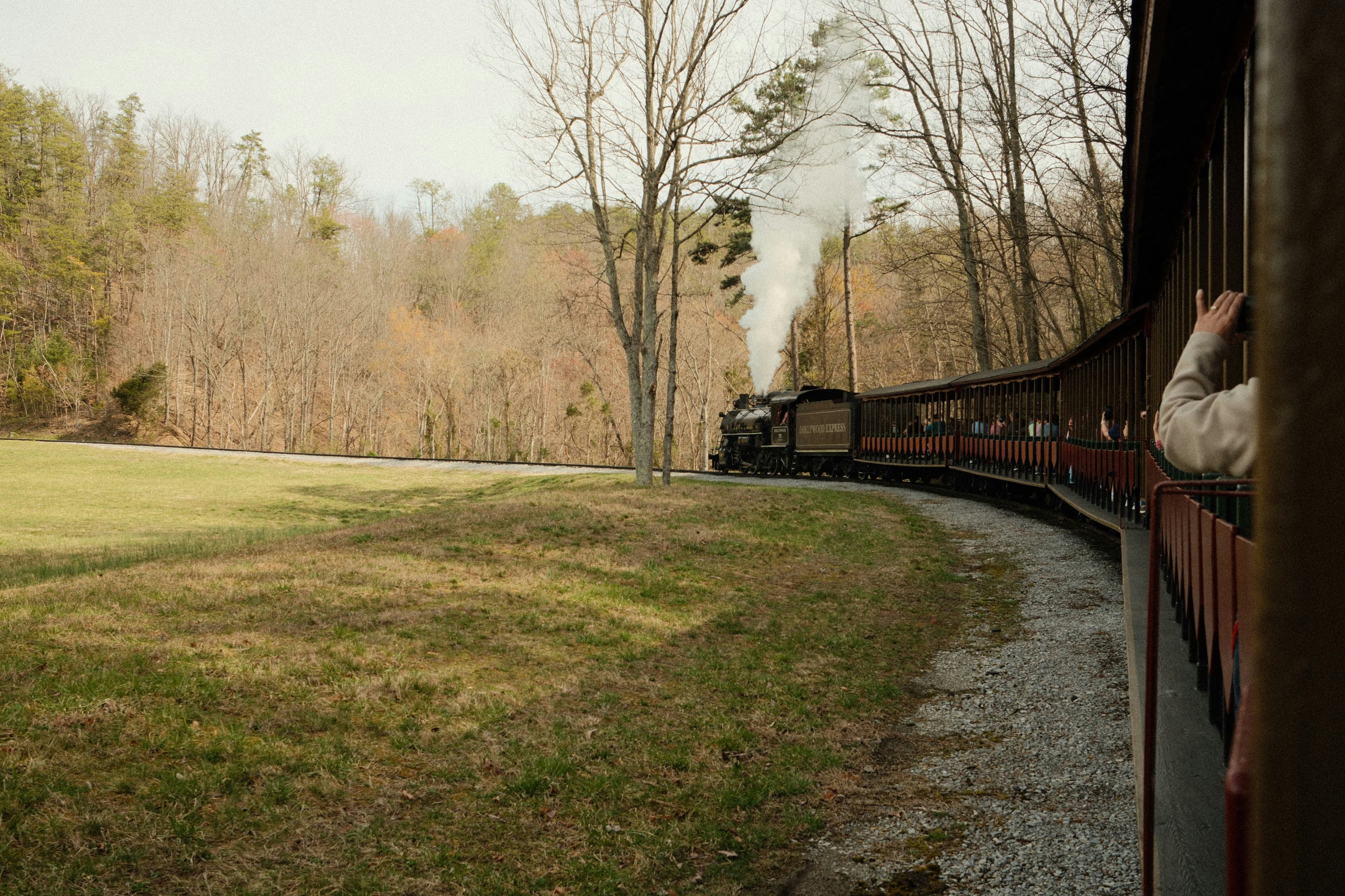 A steam train travels through a scenic landscape.
