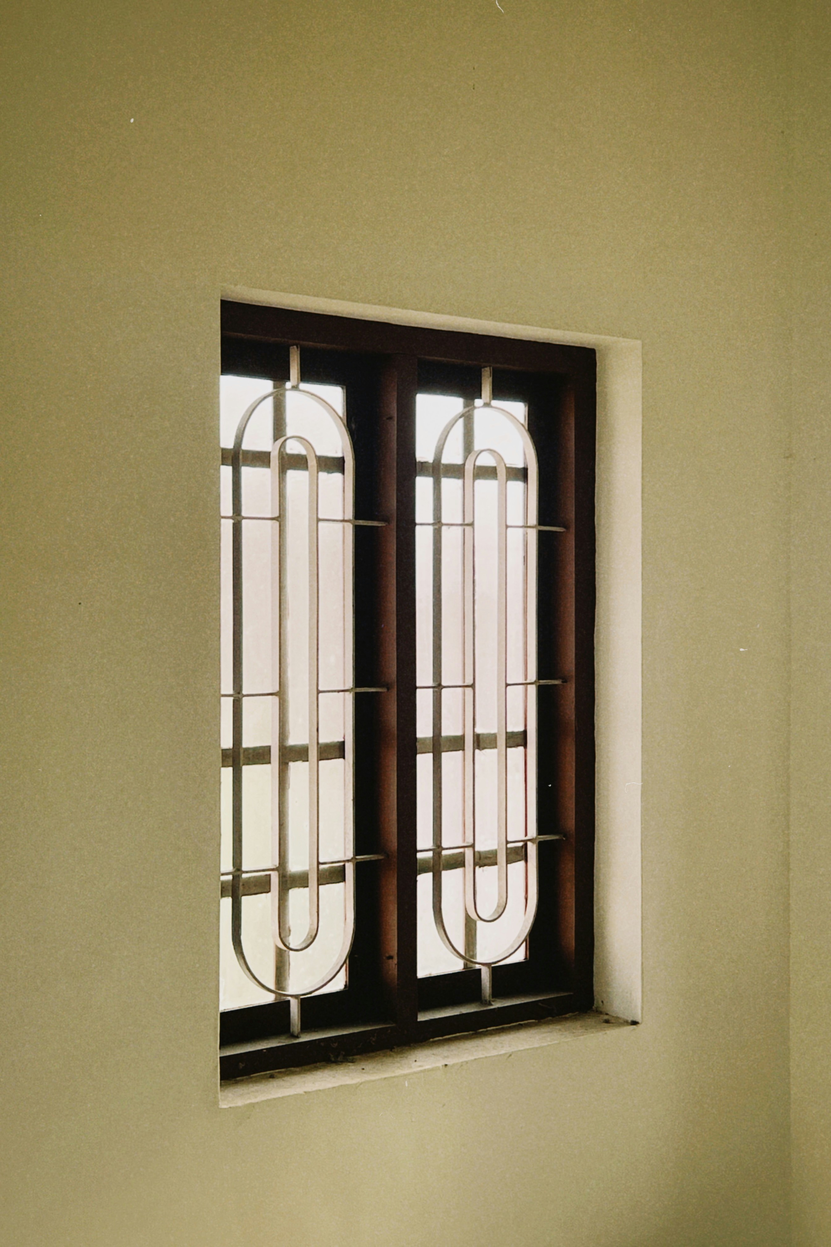 Symmetry in Light: dual-window ironwork bathed in warm interior glow