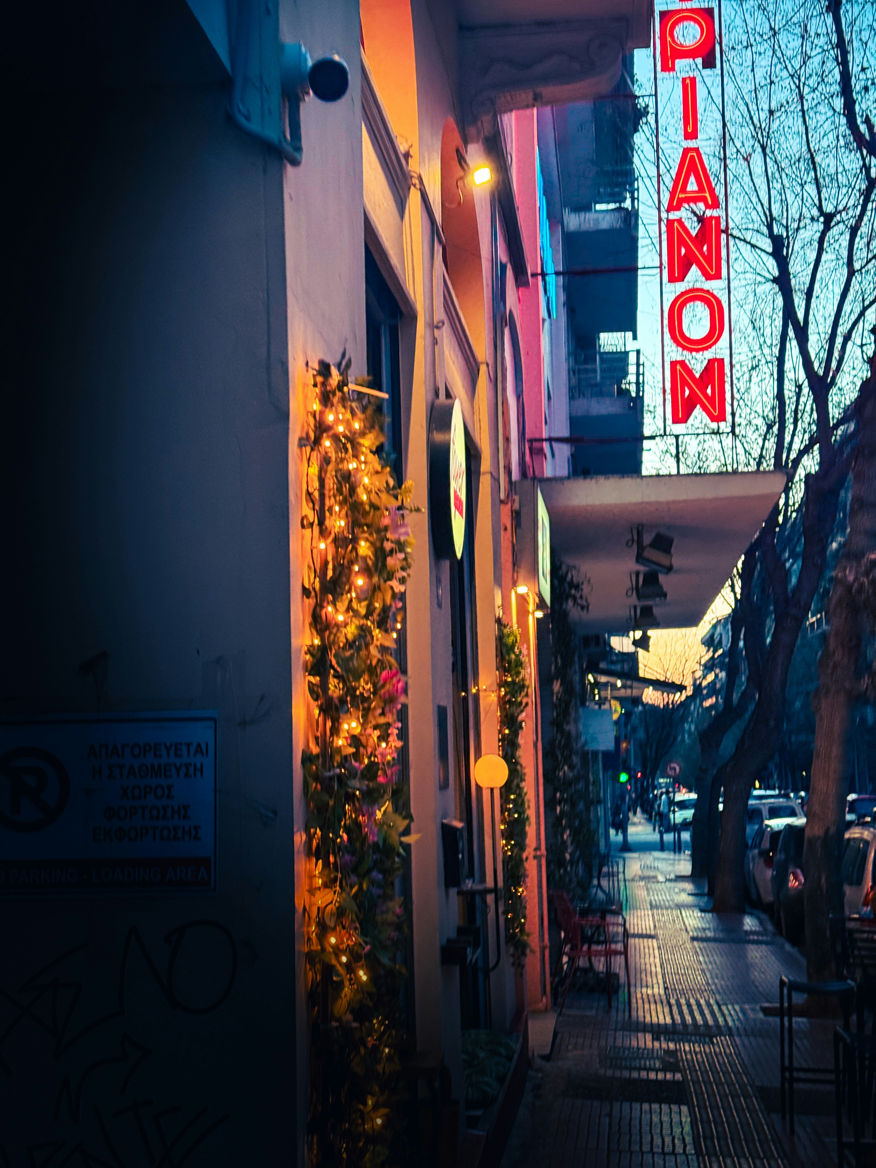 Neon Piano Sign Over a Dusk-Lit Café Street