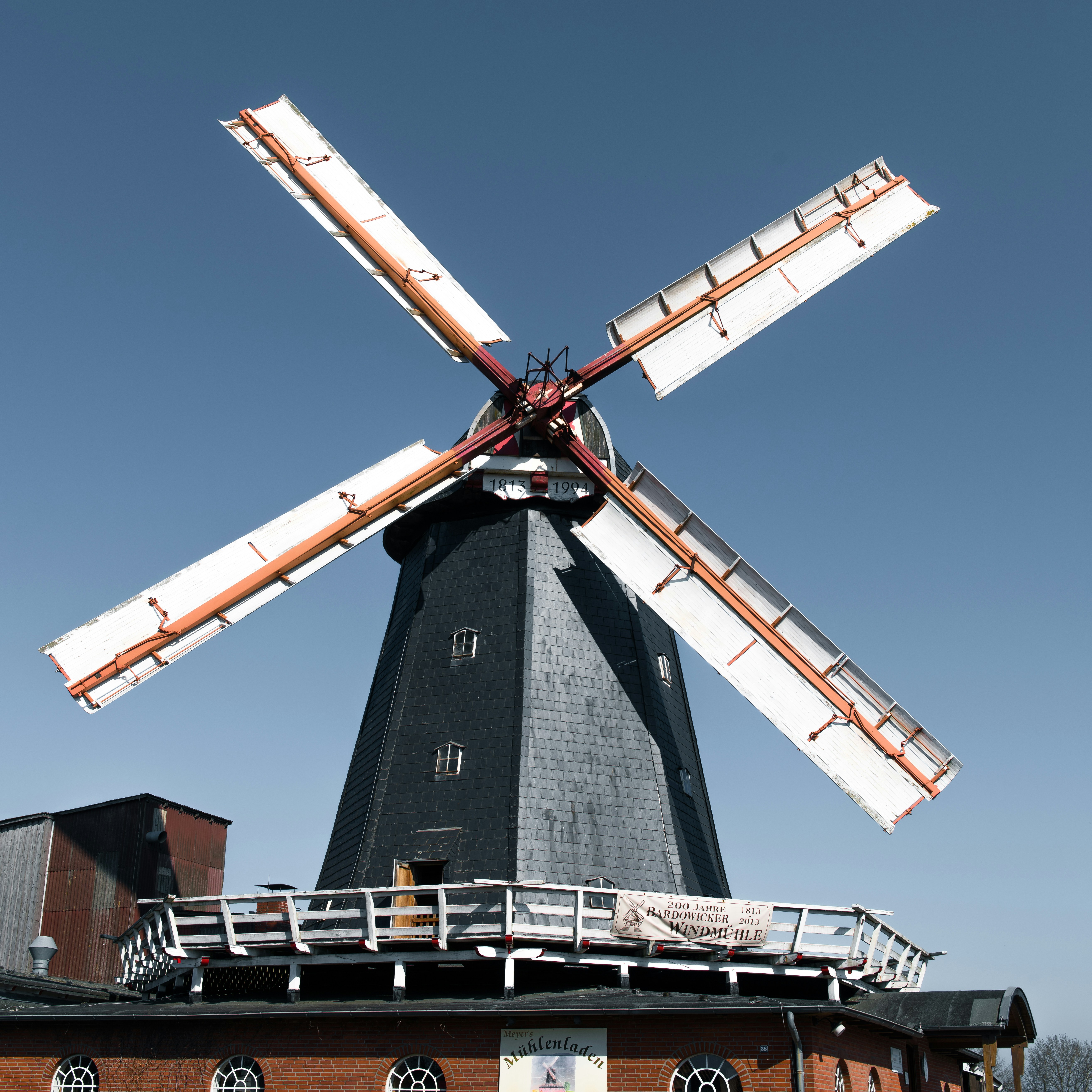 Crosswind Keeper: The Windmill Tower Reaches into a Clear Sky