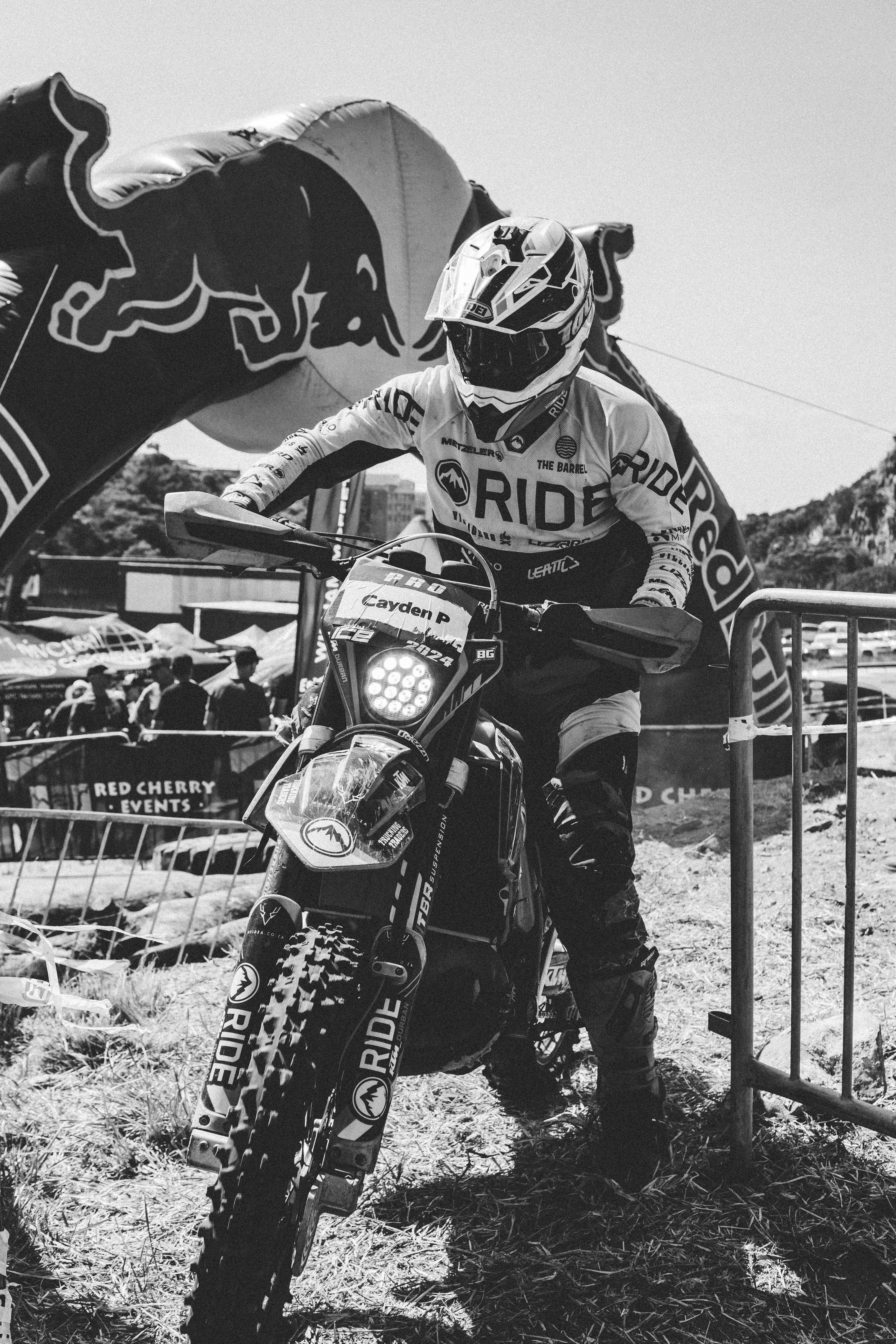 Grit at the Gate: A motocross rider beneath Red Bull banners