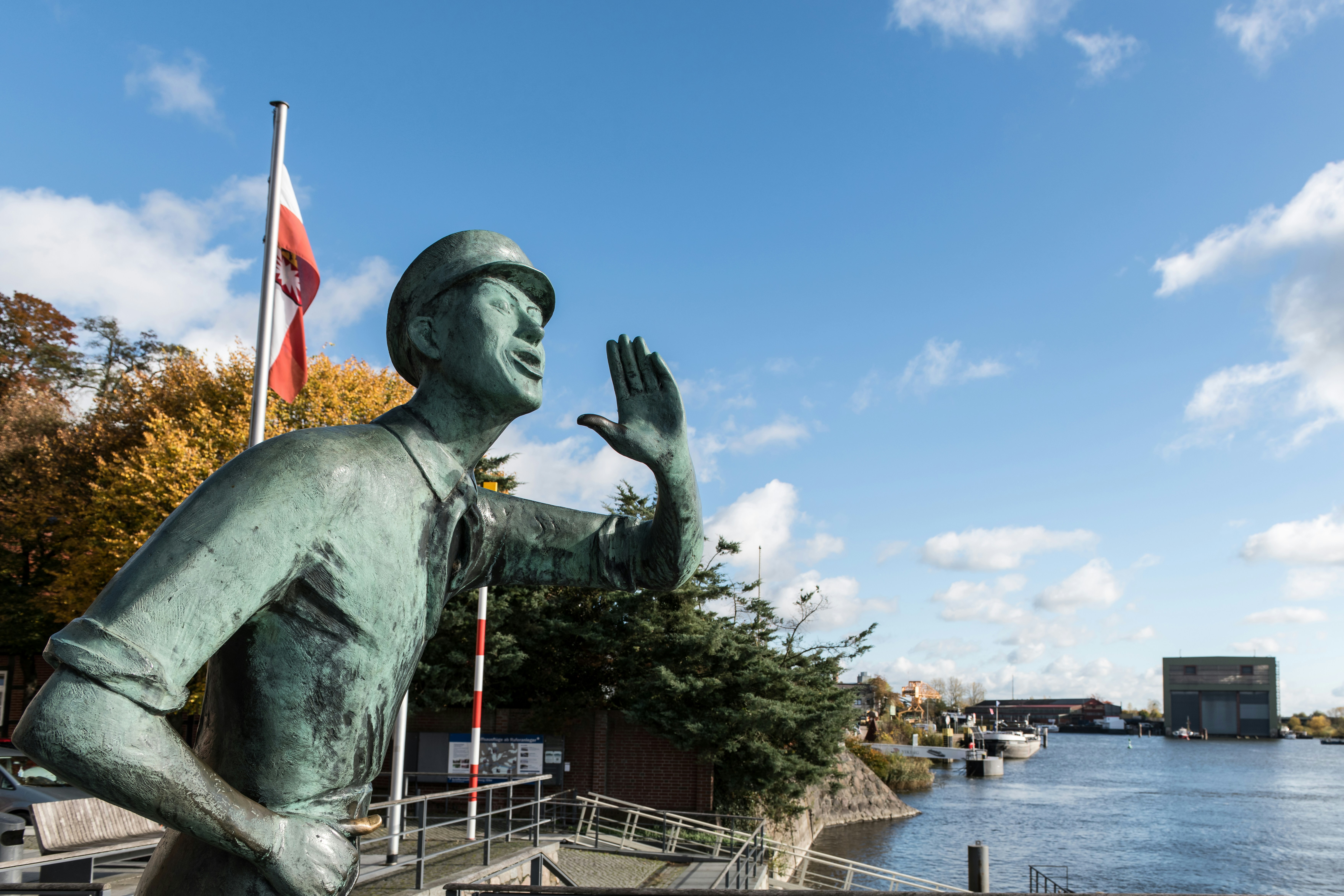 A statue of a worker looks out over the water. photo – Free Statue ...