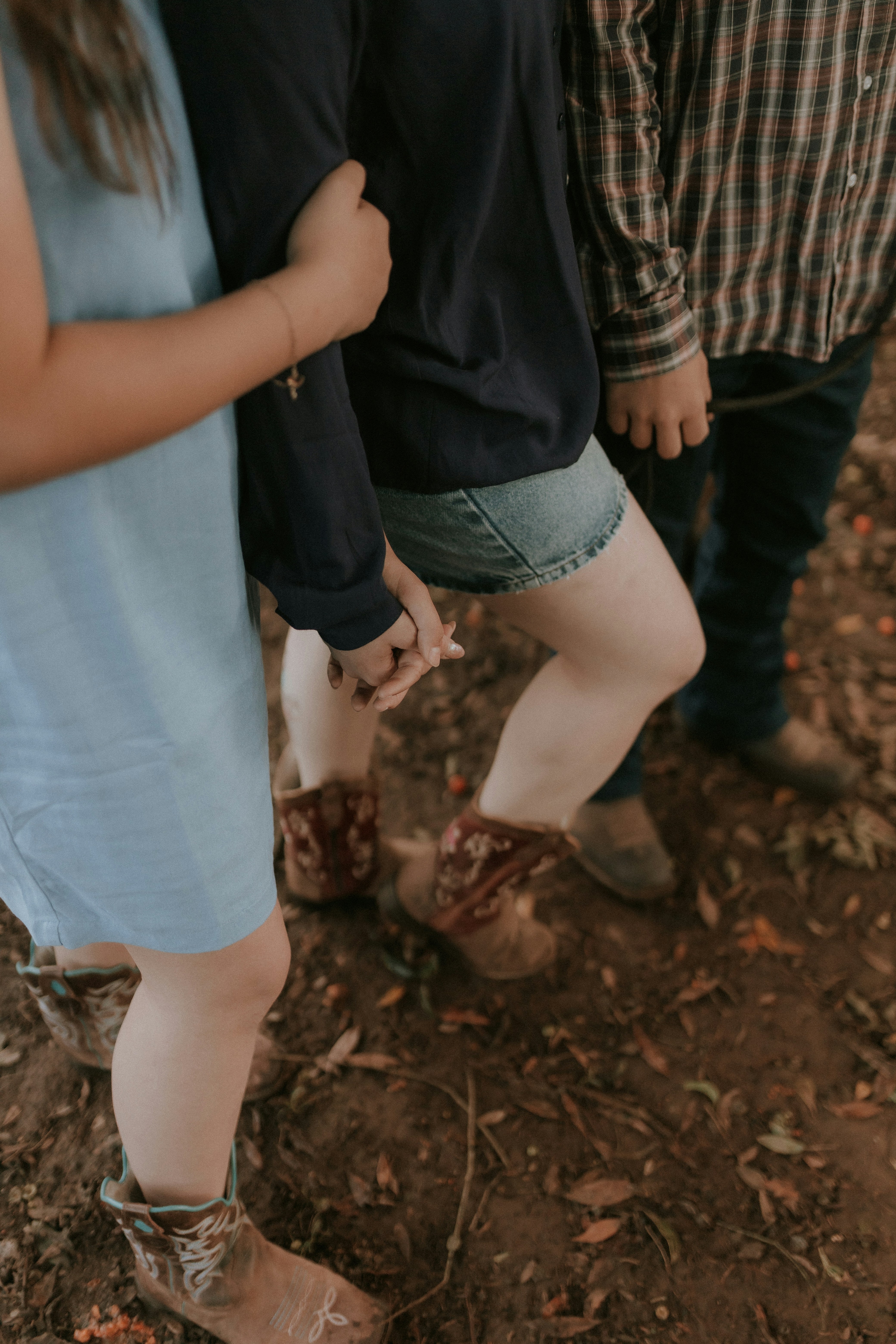 Circle of Footsteps: Friends Linked by Hands in a Dusty Clearing