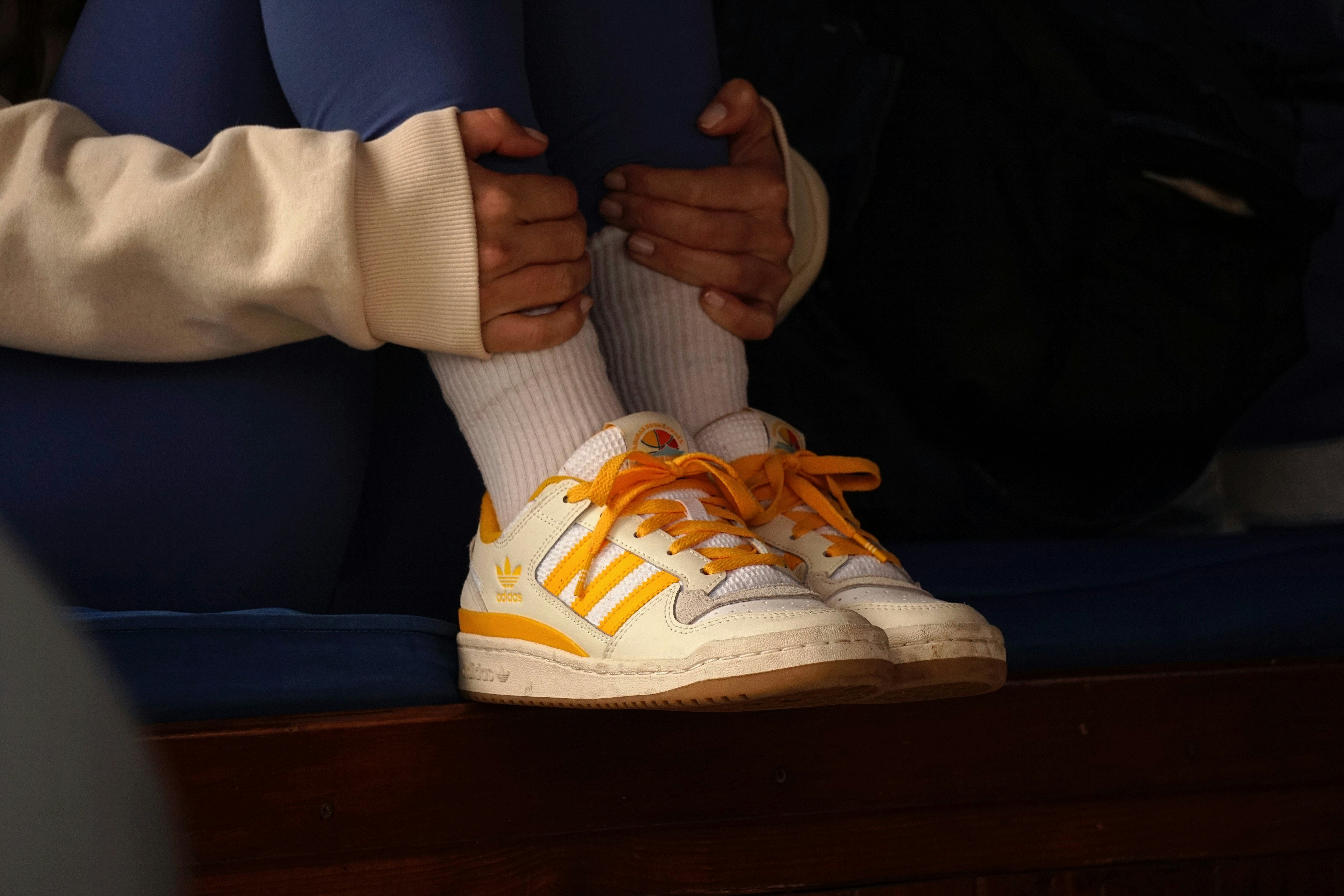 Orange-lace sneakers frame a tender bench moment