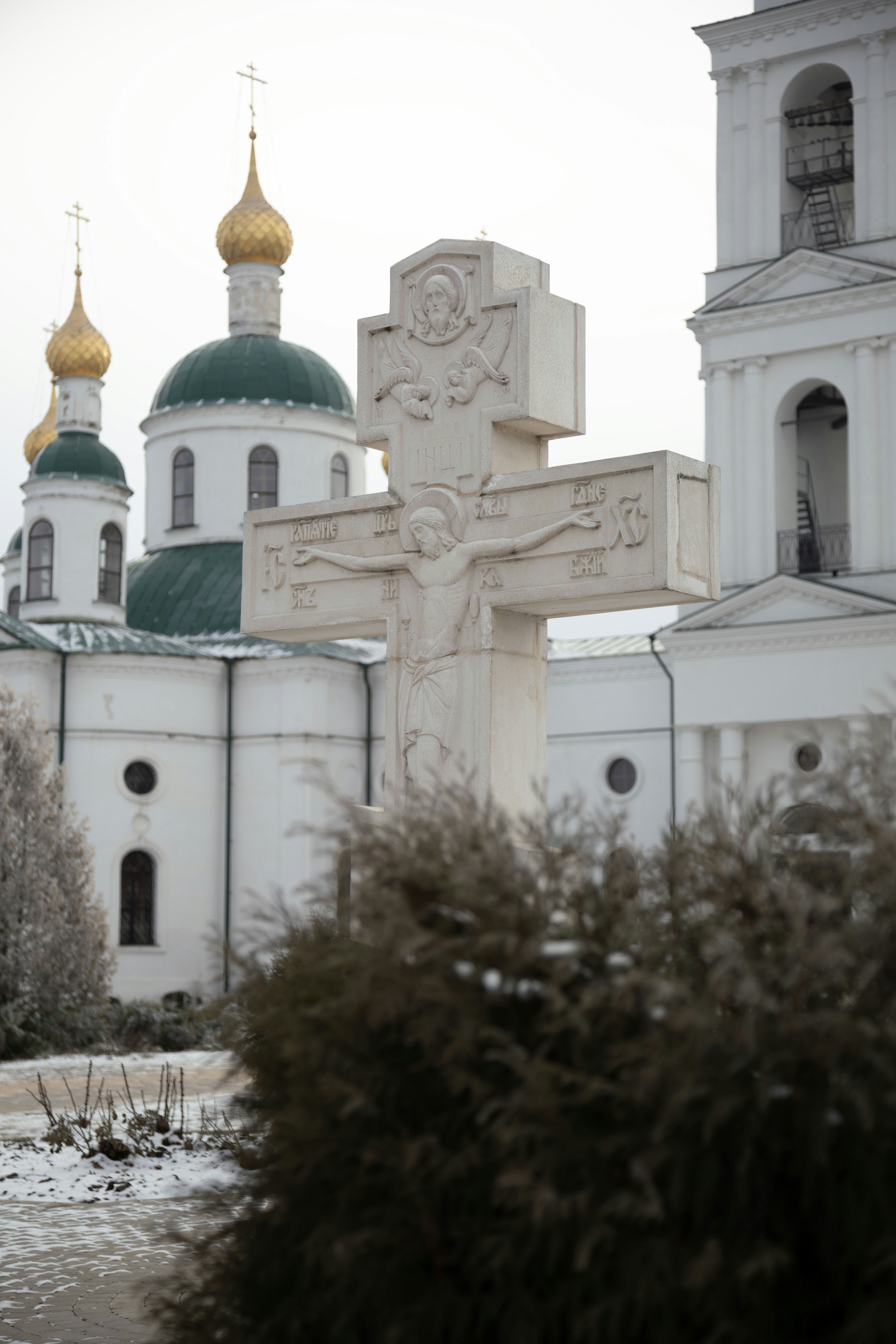 Epiphany Monastery, Uglich | A stone cross stands before a white church.