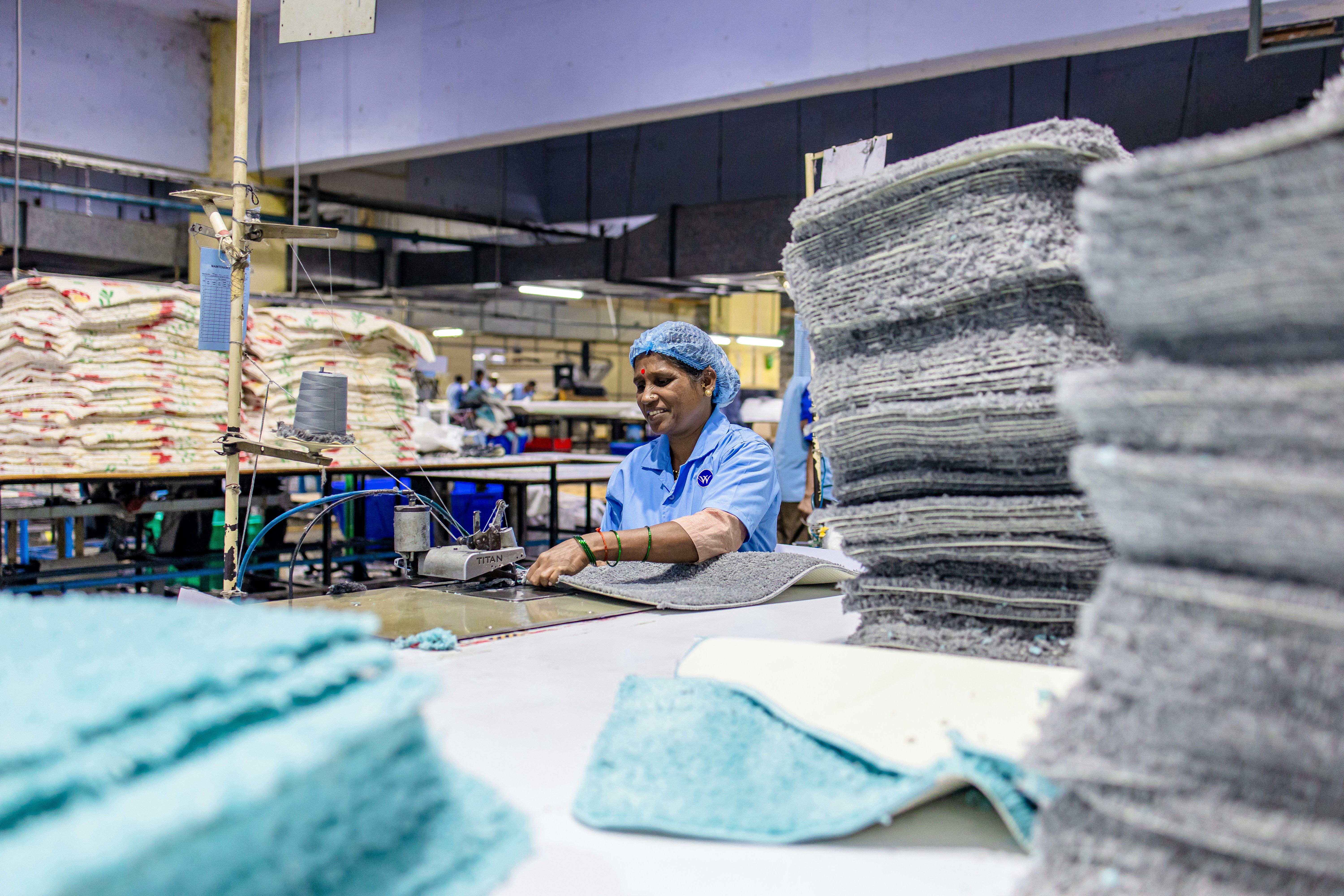 A worker handles fabric in a factory setting. photo – Free Human Image ...