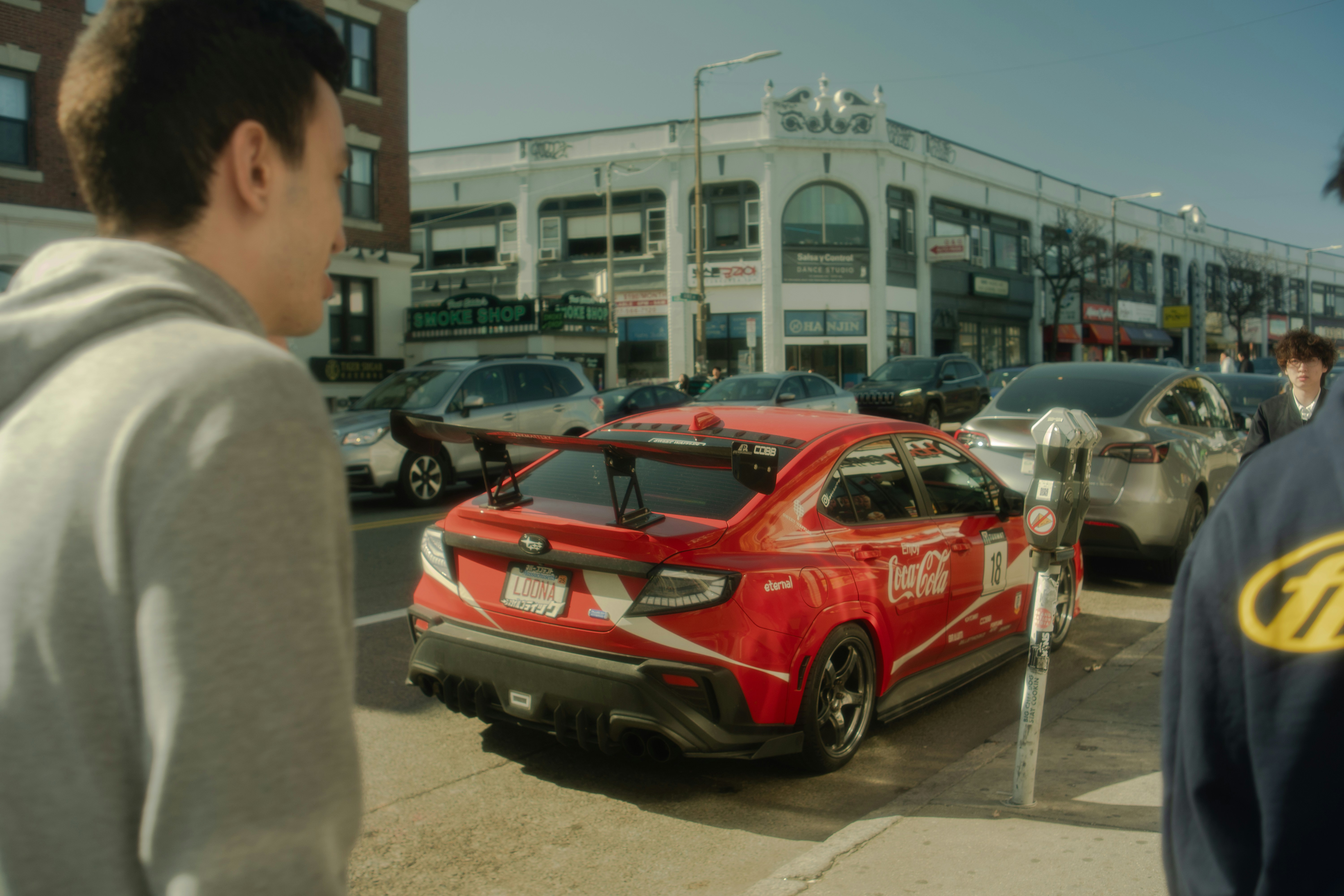 People gaze at a red, modified car on the street. photo – Free Car ...
