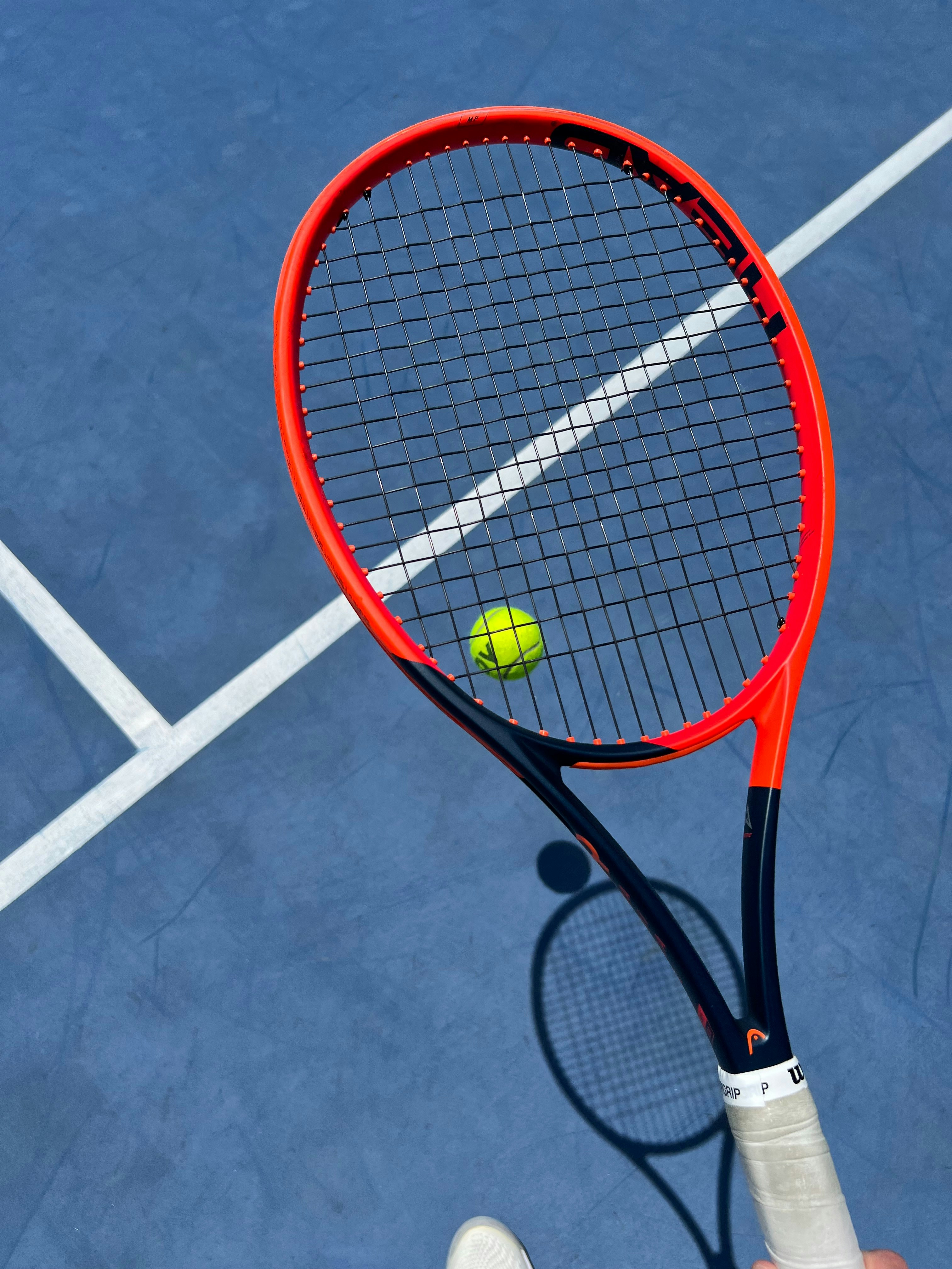 Tennis racket holding a tennis ball on the court. photo – Free Sport ...