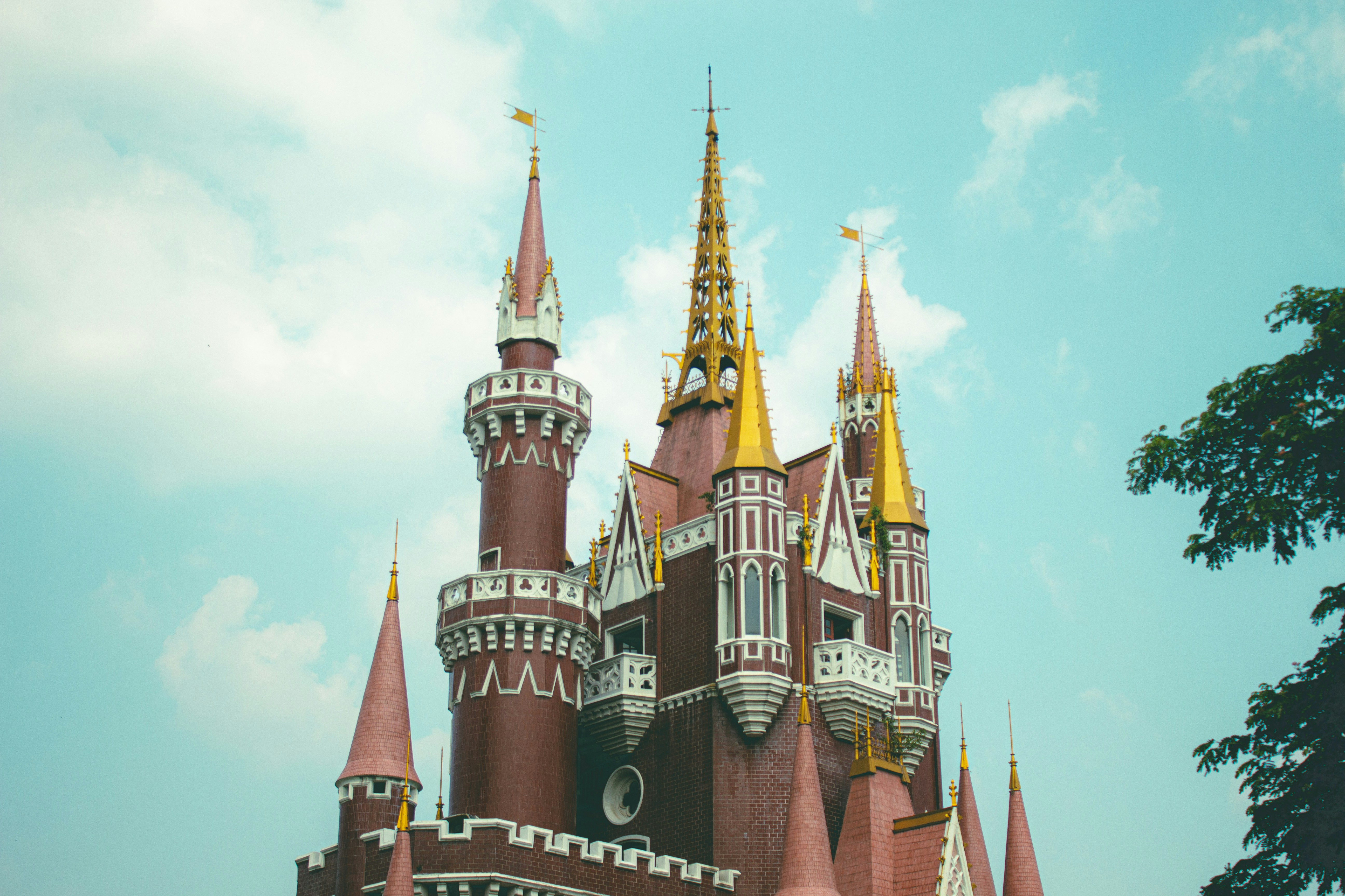 Gothic-style castle with golden spires under a bright blue sky.