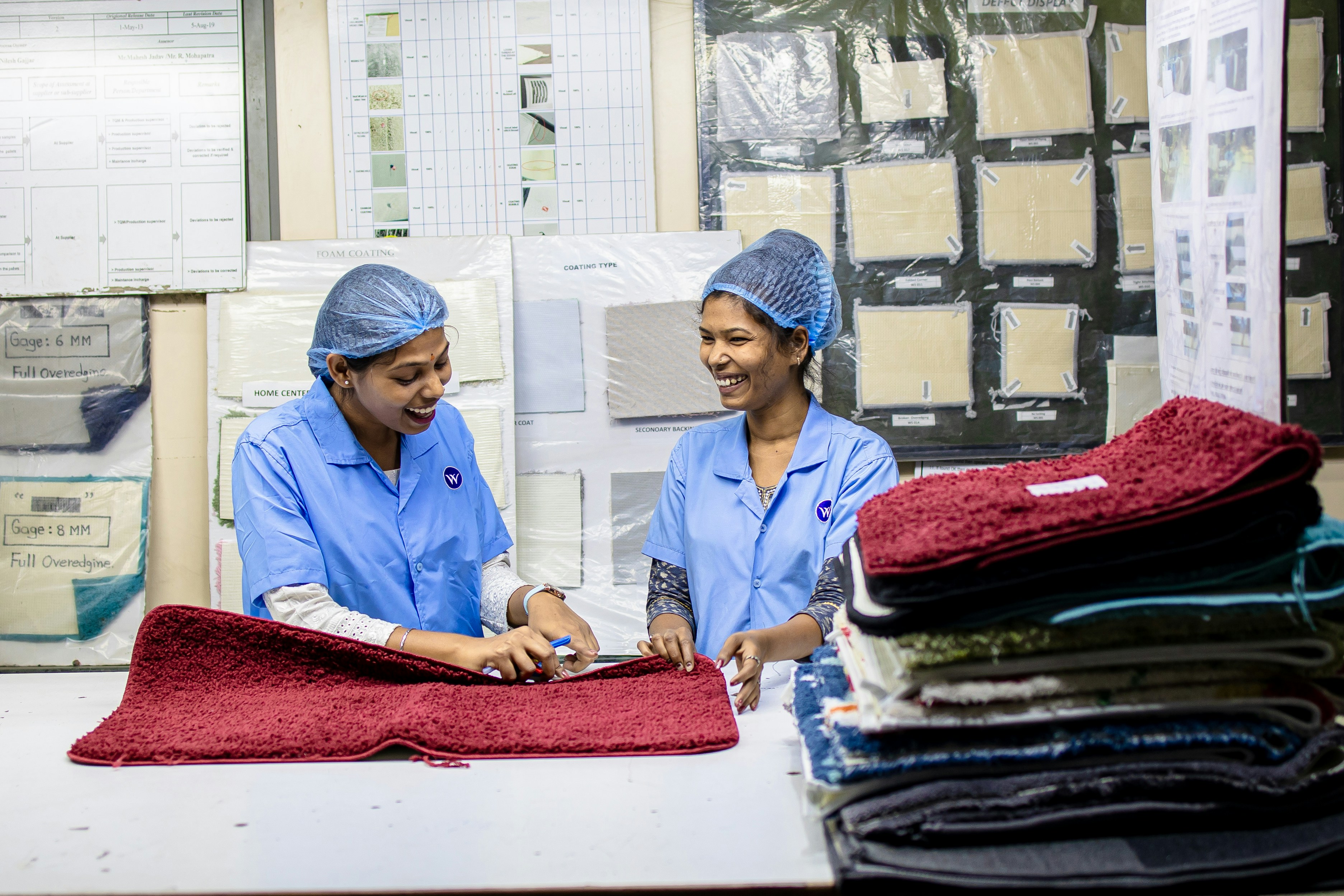 Two women in a factory inspect and arrange rugs. photo – Free Woman ...
