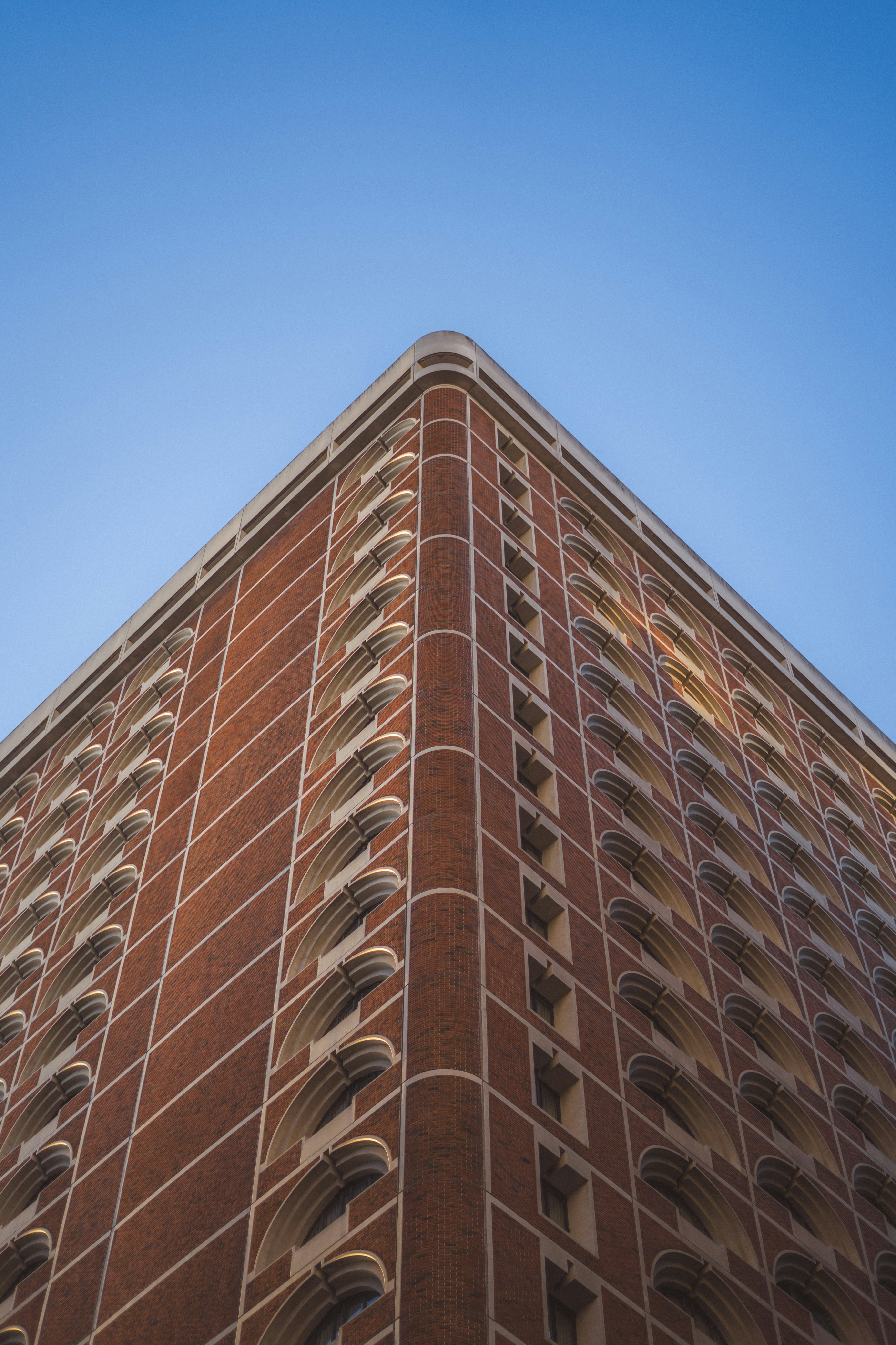 A tall building angles toward the blue sky. photo – Free Building Image ...