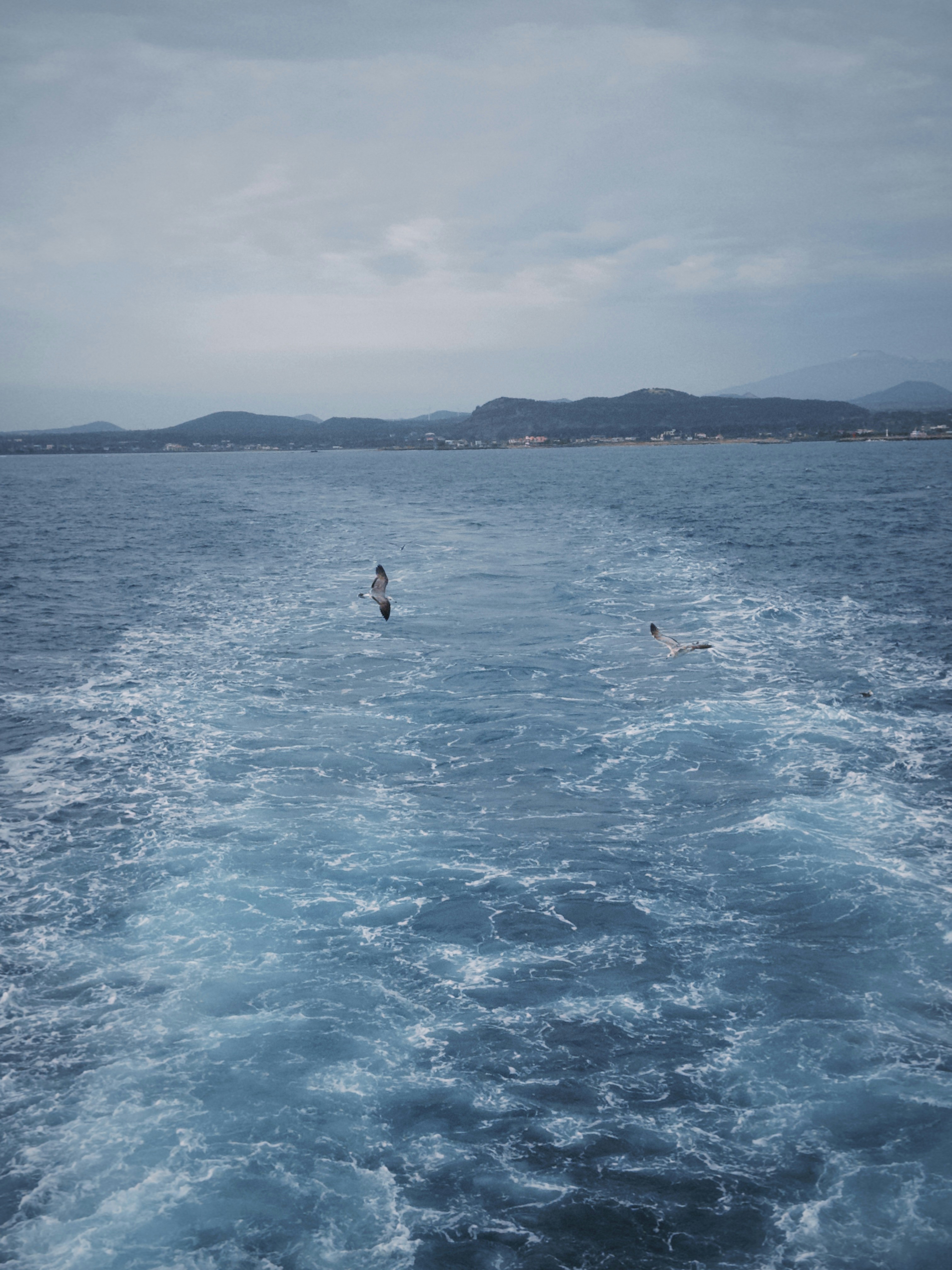 Waves churn behind a boat on the ocean. photo – Free Sea Image on Unsplash