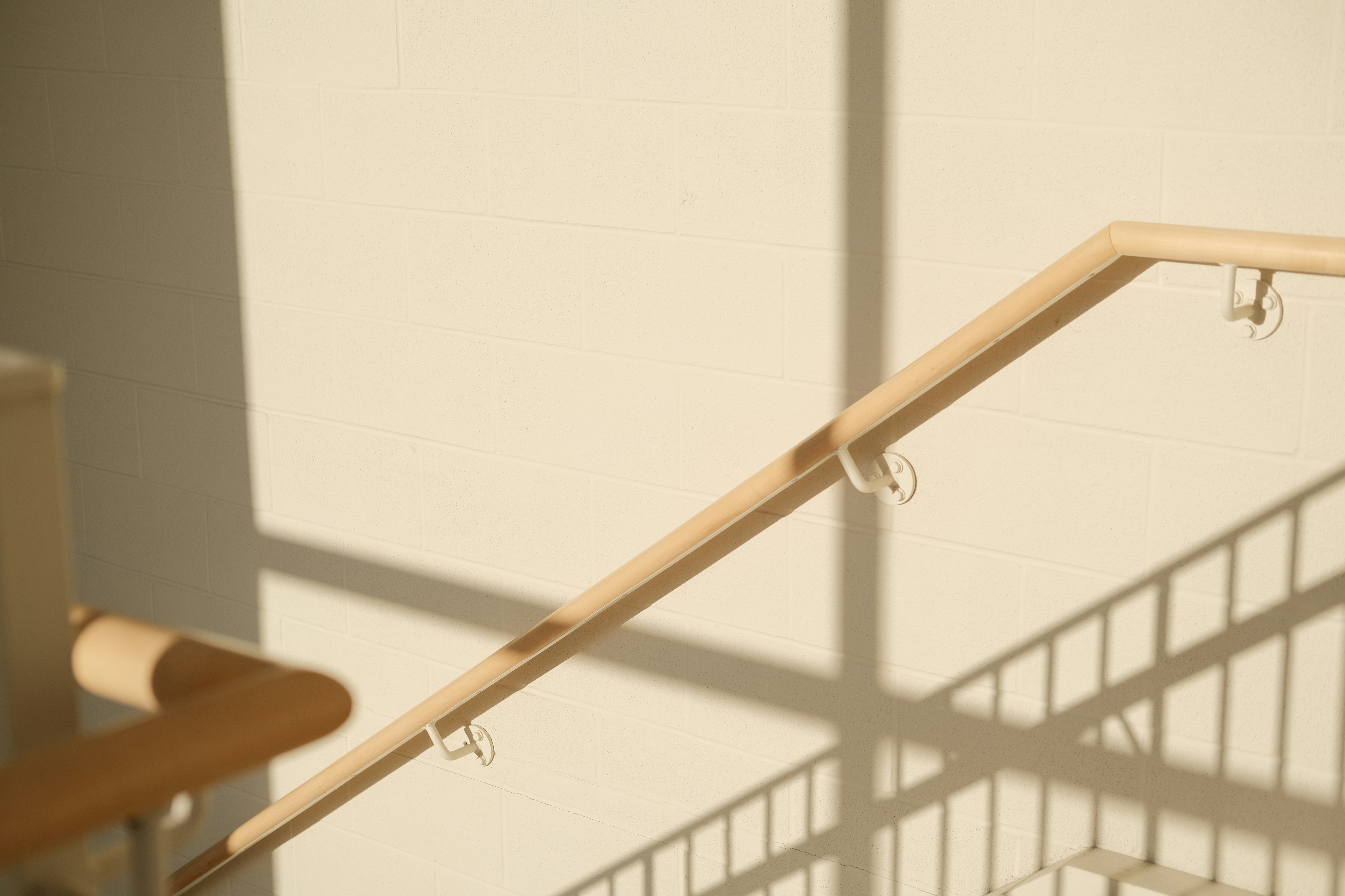 Staircase with railing casting shadows on the wall. photo – Free ...