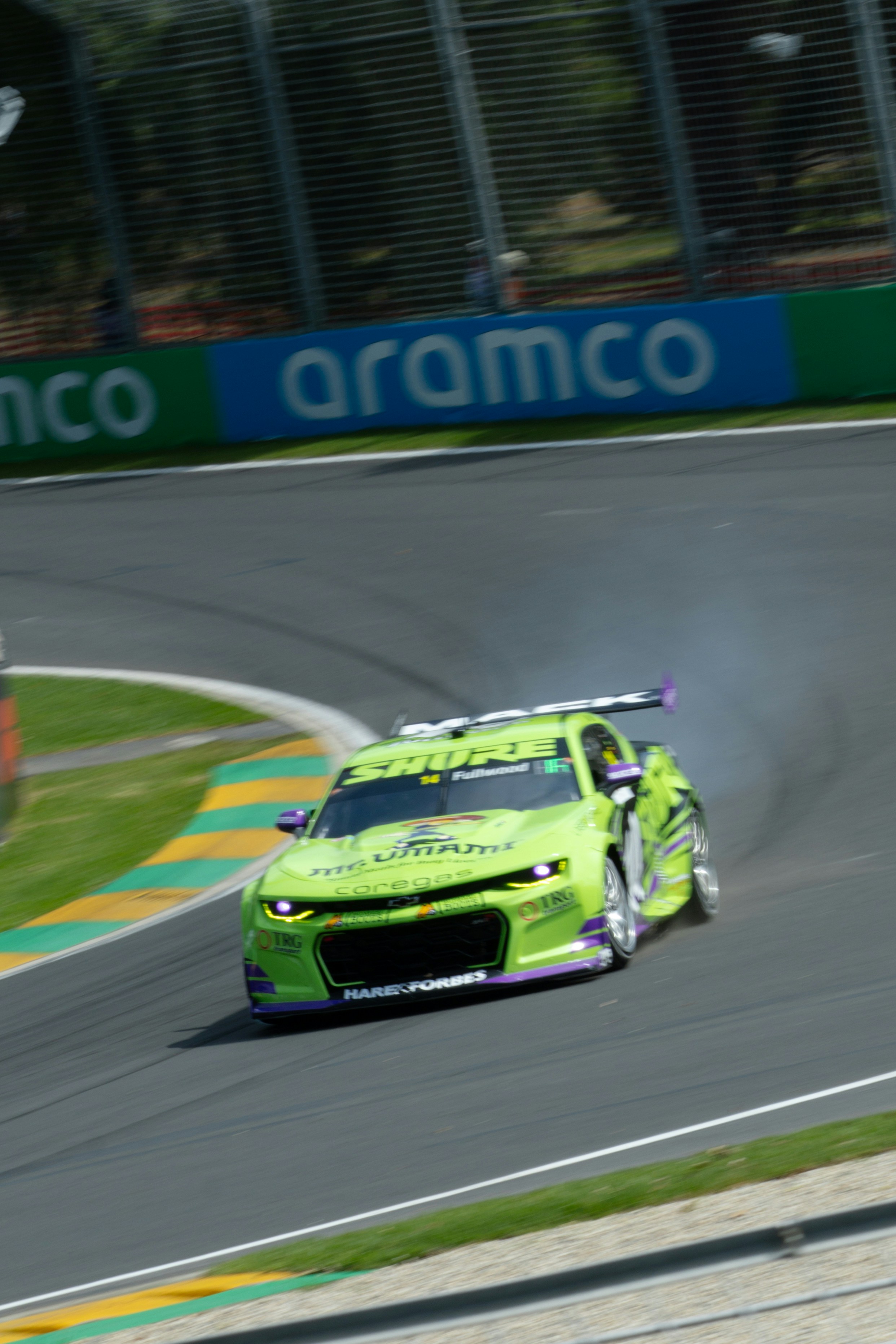 Neon-green racer carving a high-speed arc through a sunlit chicane