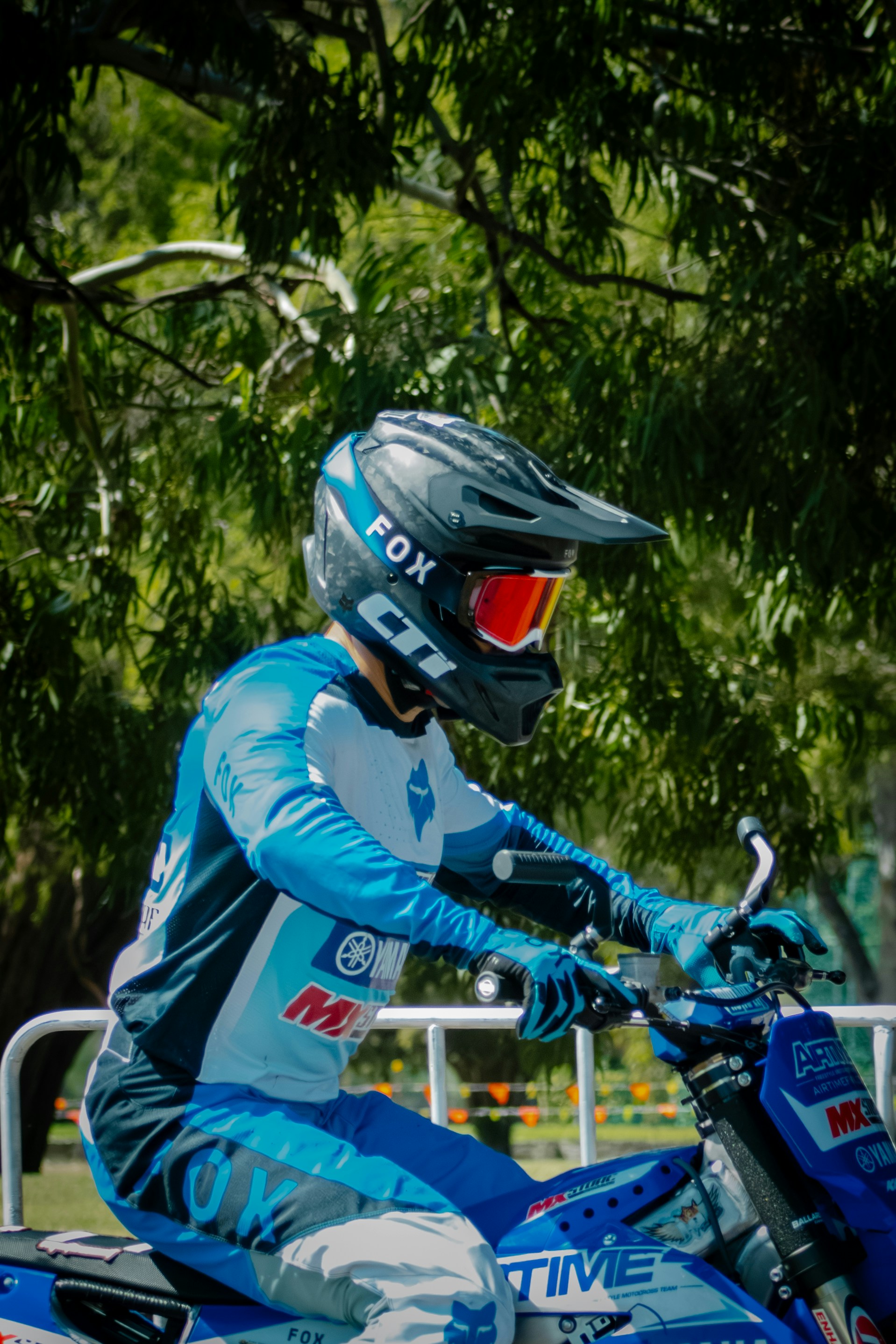 Fox-Blue Moto Portrait: Rider in a Sun-Dappled Park