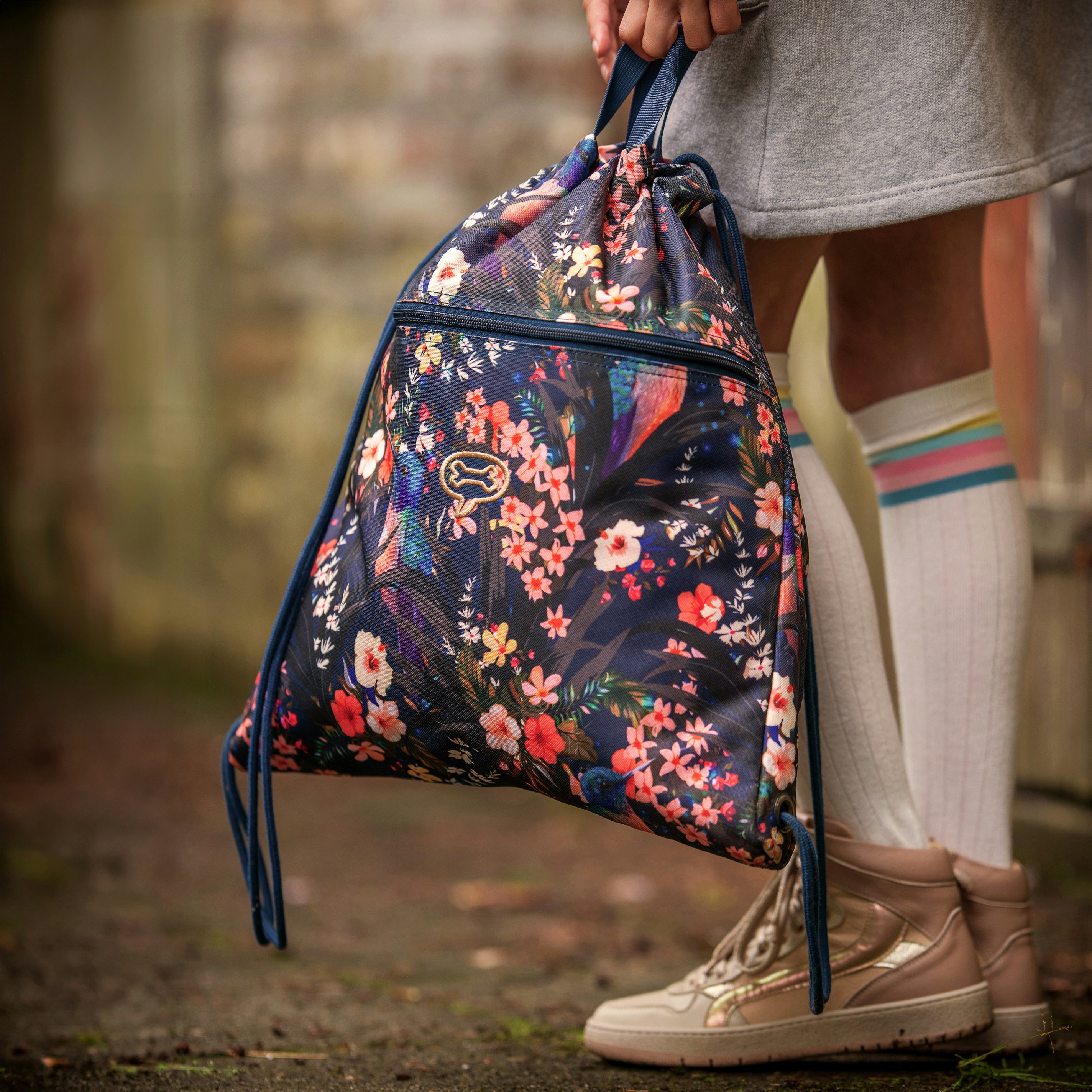 A girl holds a floral drawstring backpack. photo – Free Bag Image on Unsplash