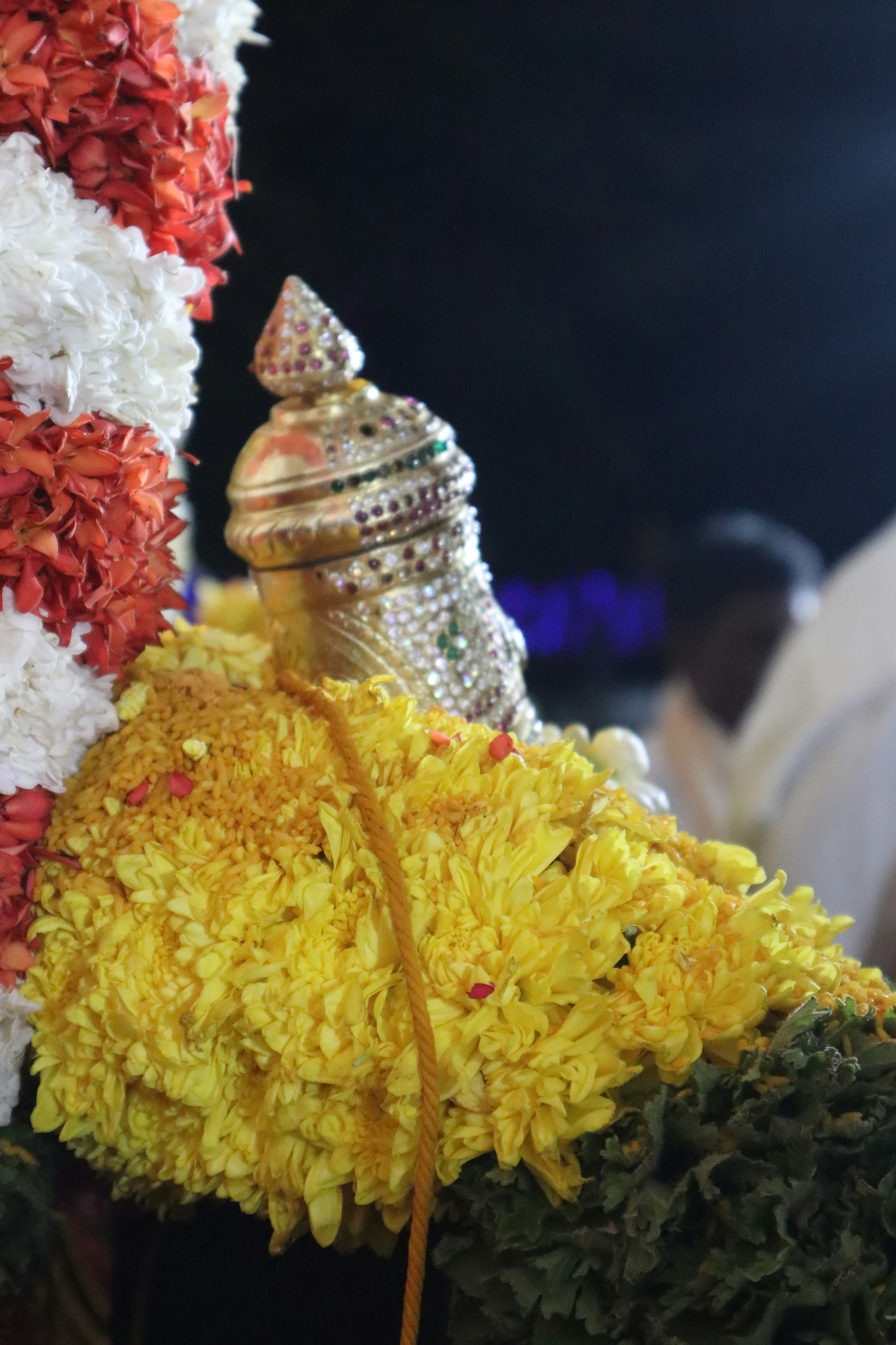 A religious idol draped in vibrant yellow flowers. photo – Free Woman ...