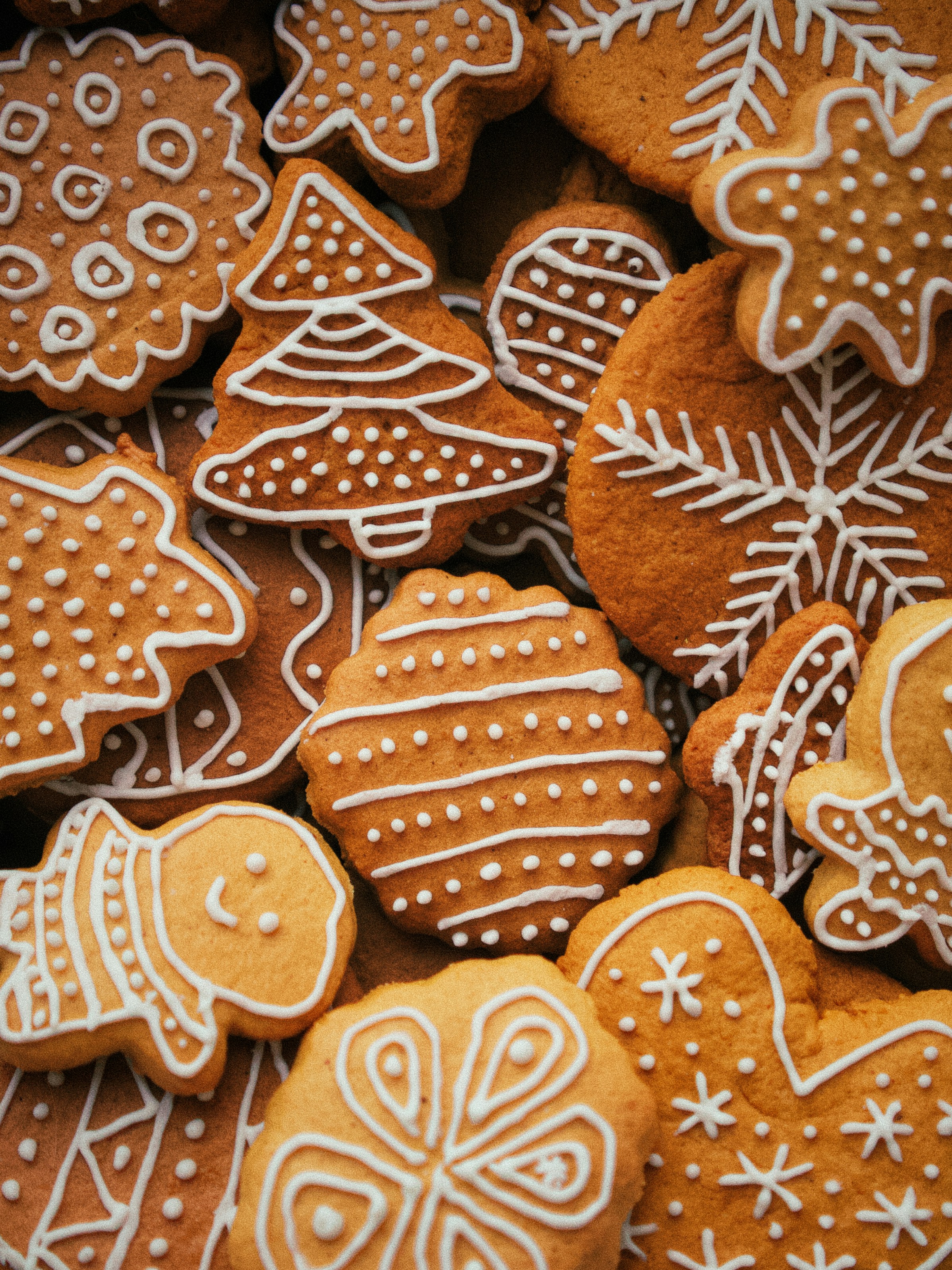 A delightful assortment of intricately decorated gingerbread cookies featuring various holiday shapes and designs.