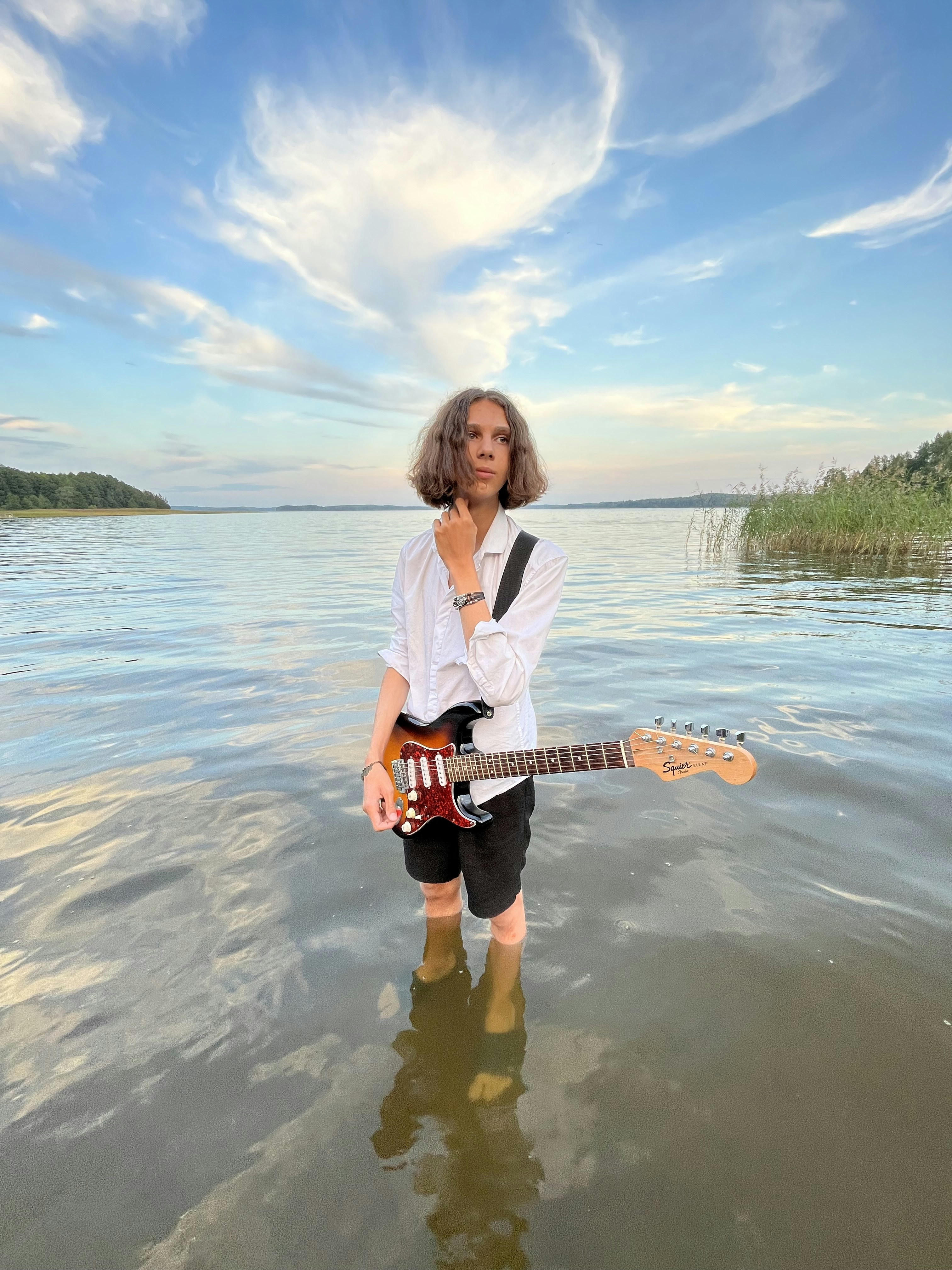 A young musician stands in the lake with his guitar. photo – Free Music ...