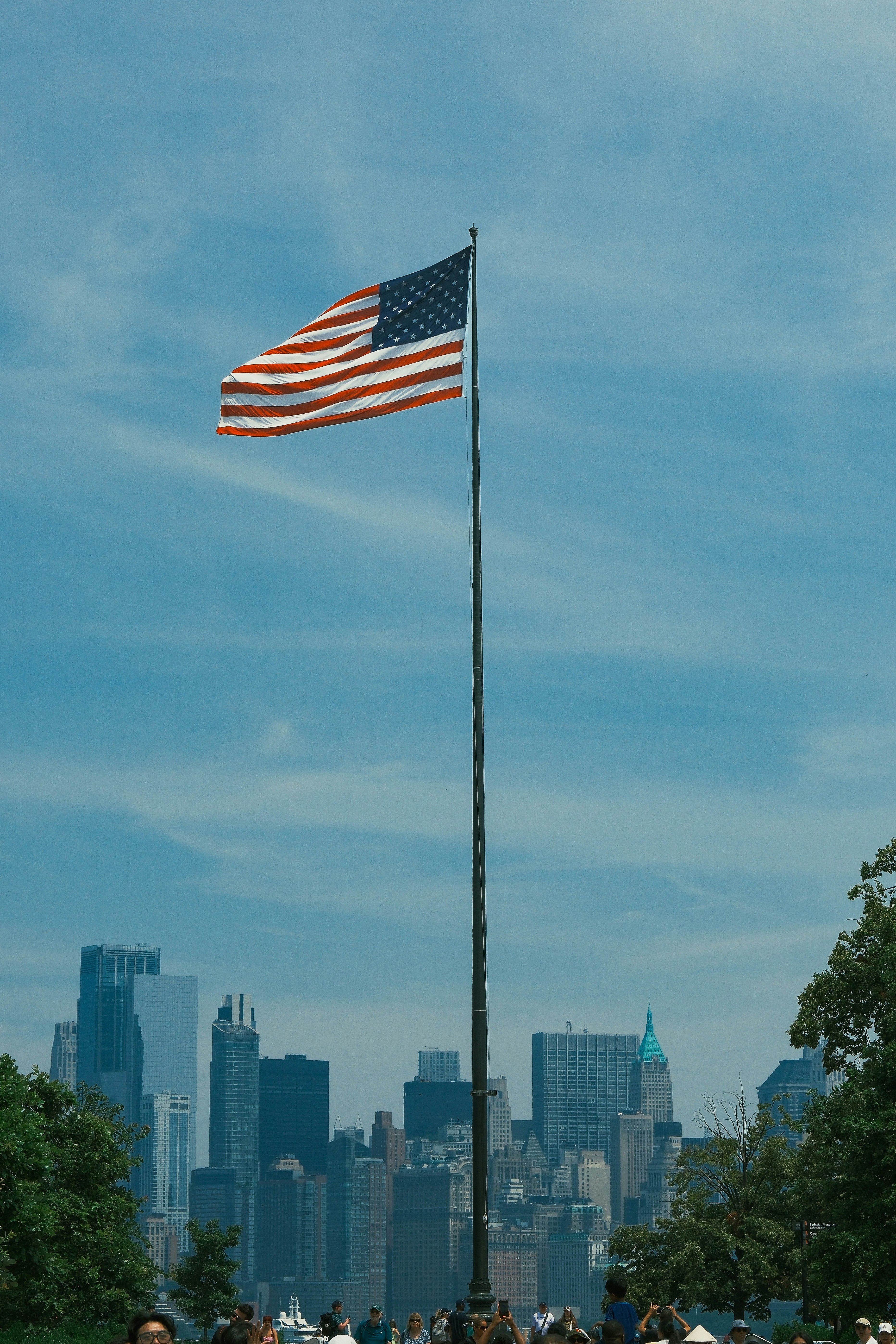 Flagpole Over the City: A Quiet Moment Beneath a Blue Sky