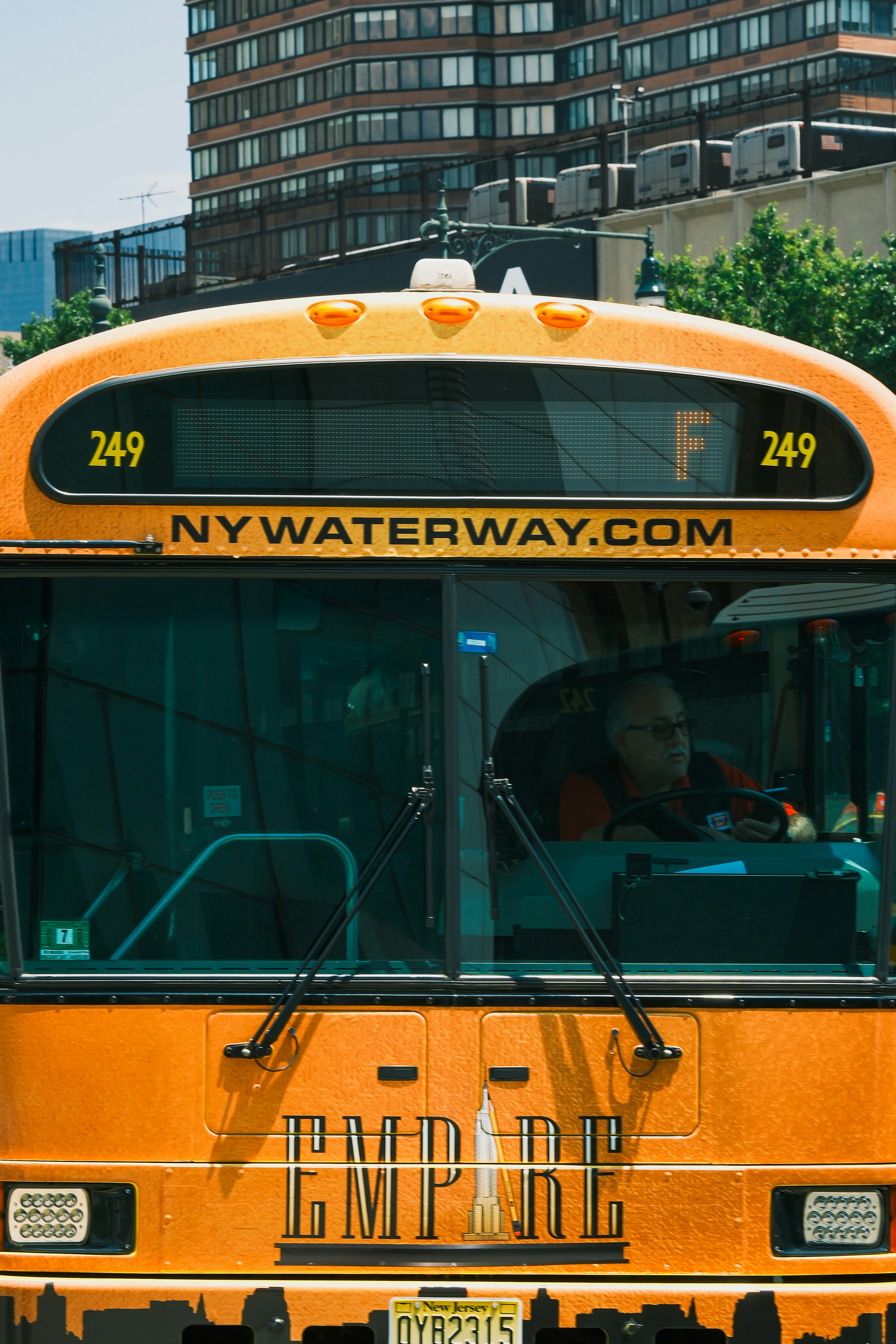 Empire at the Helm: An Orange NY Waterway Bus Anchors a City Scene
