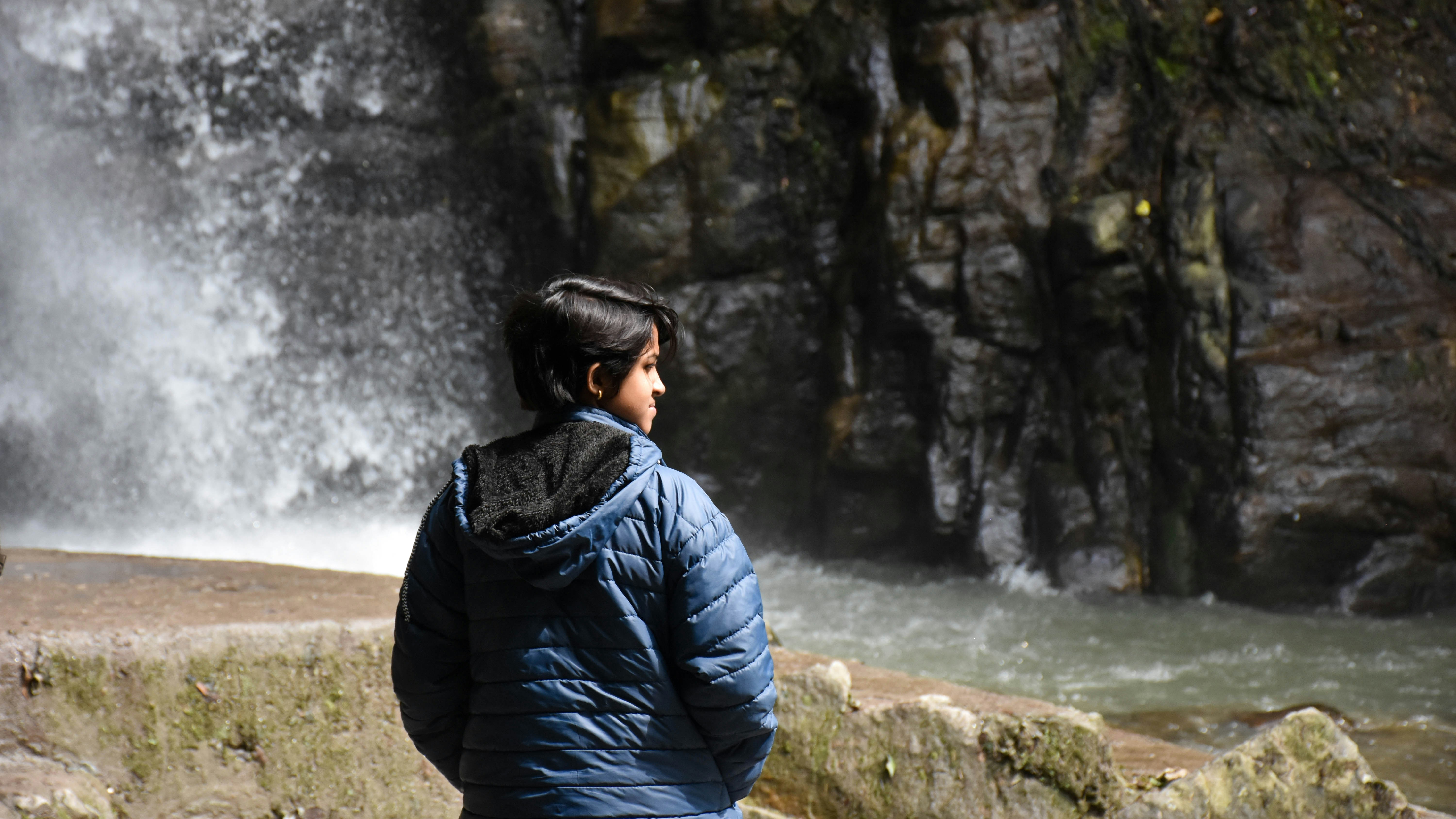 A person looks at a beautiful waterfall. photo – Free Portrait Image on ...
